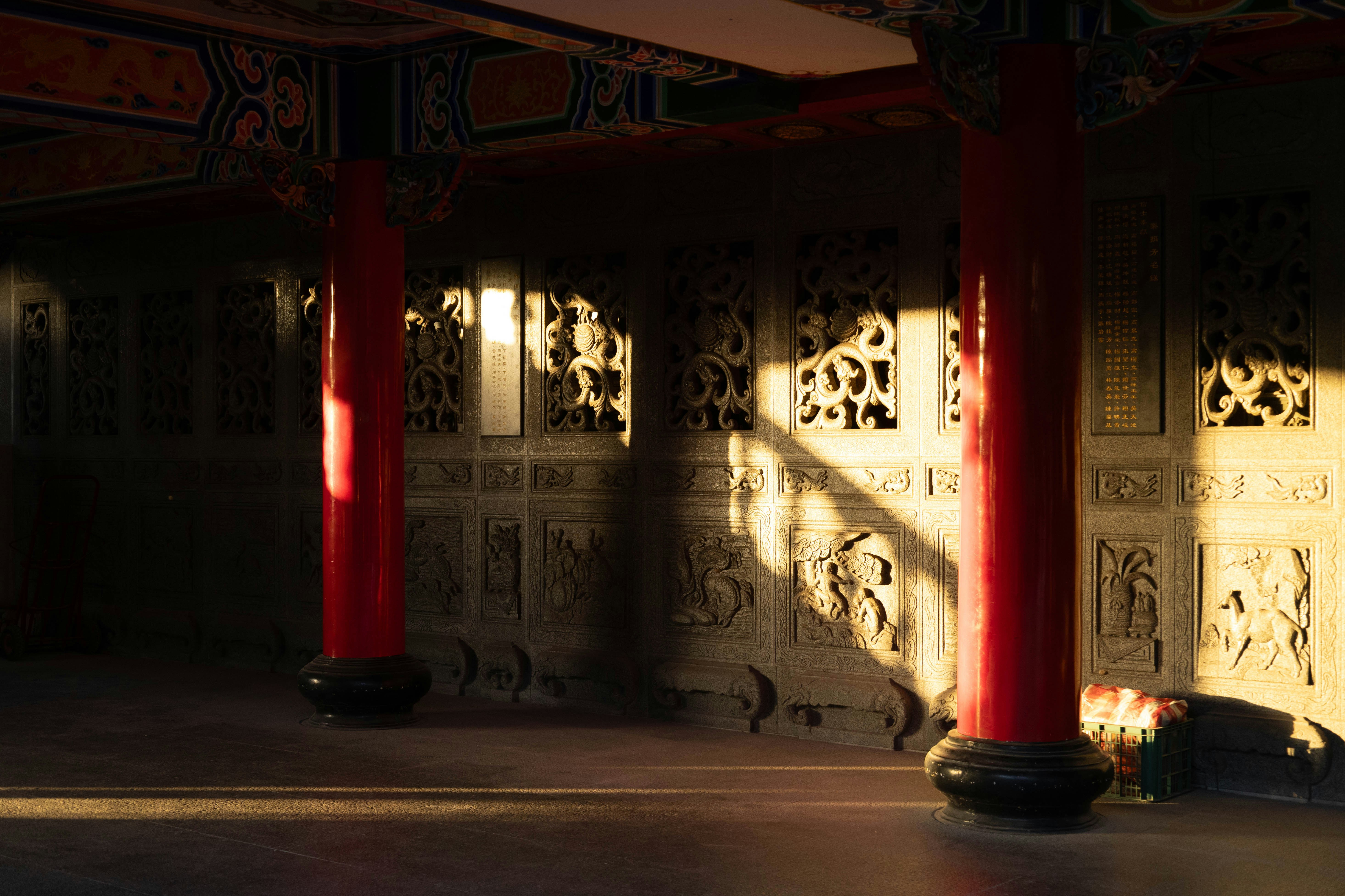 Sunlit Columns and Carved Wall Reveal in Quiet Temple Corridor