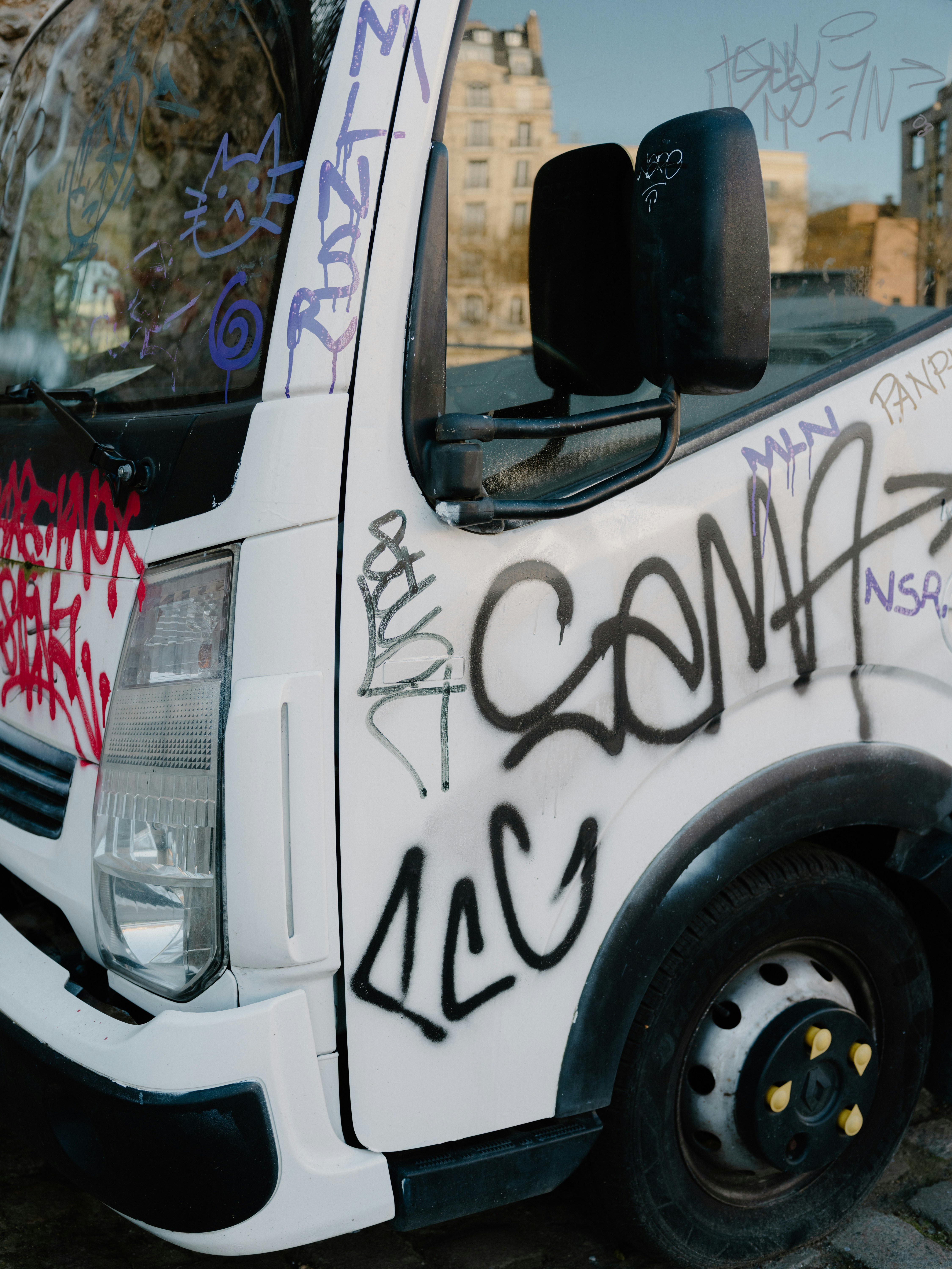 Graffiti-Scrawled Van: A City-Caught Moment in White