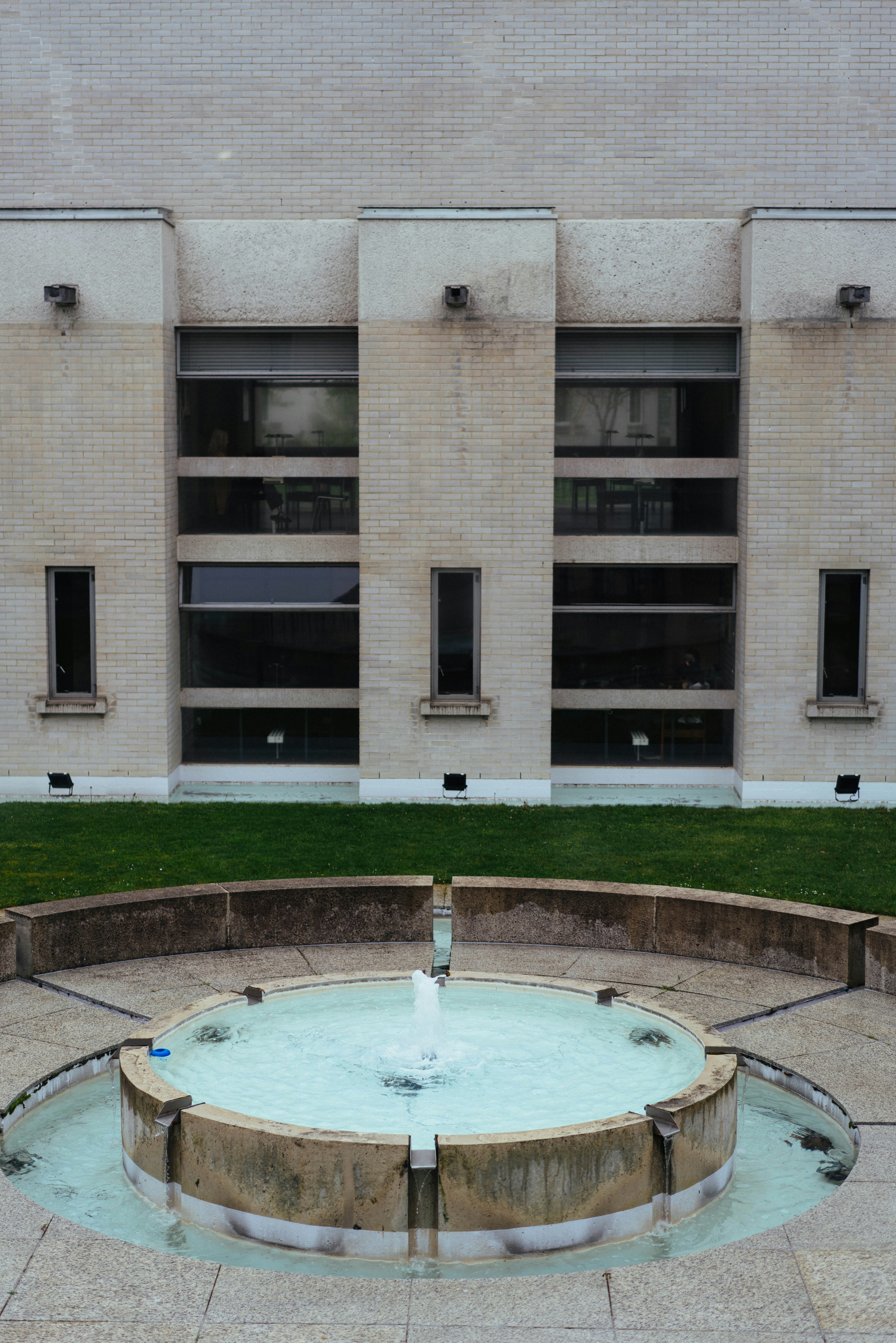 Circular Fountain Framed by a Minimalist Facade