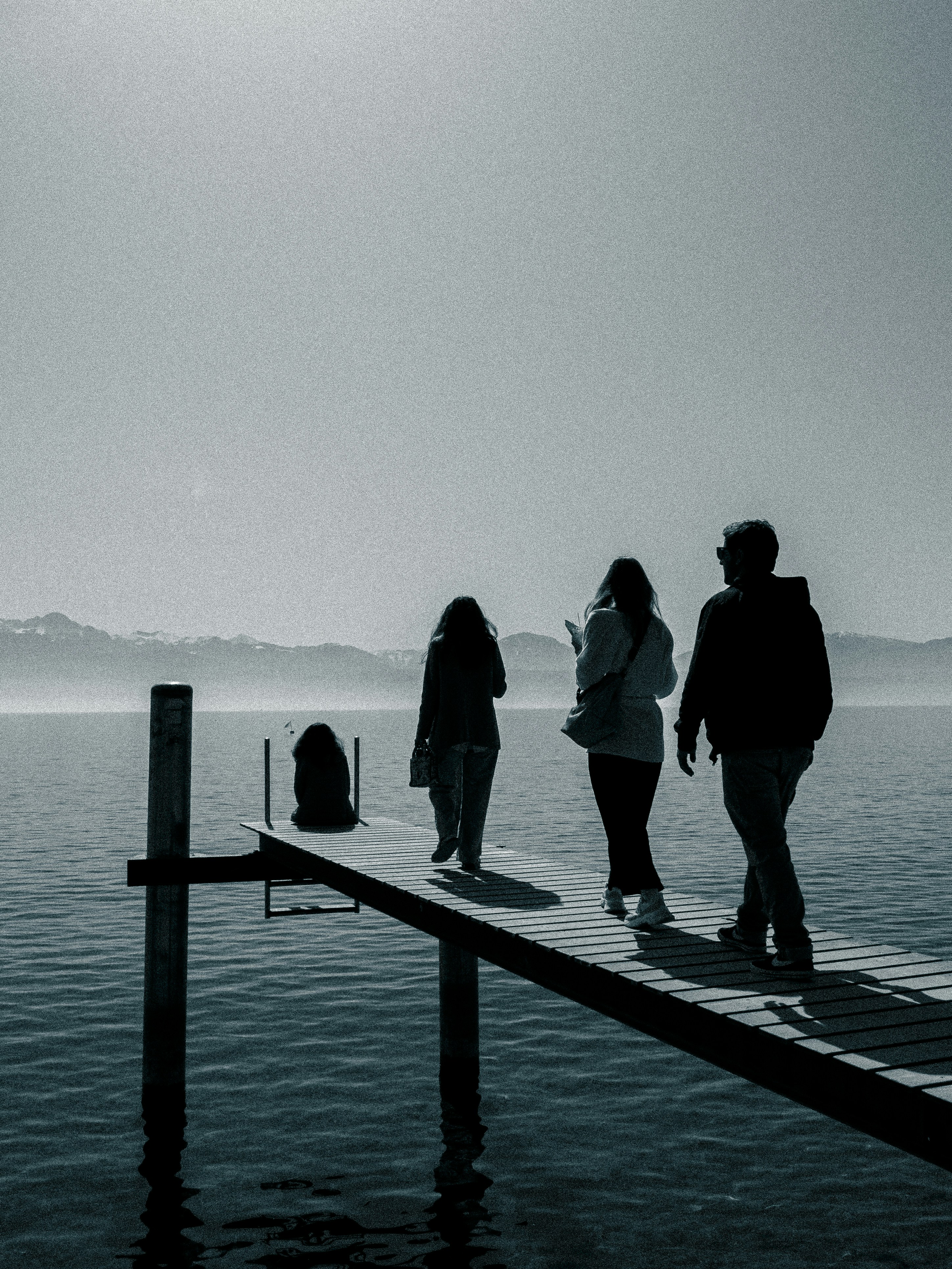 A Quiet Walk on the Pier: silhouettes against a misty horizon