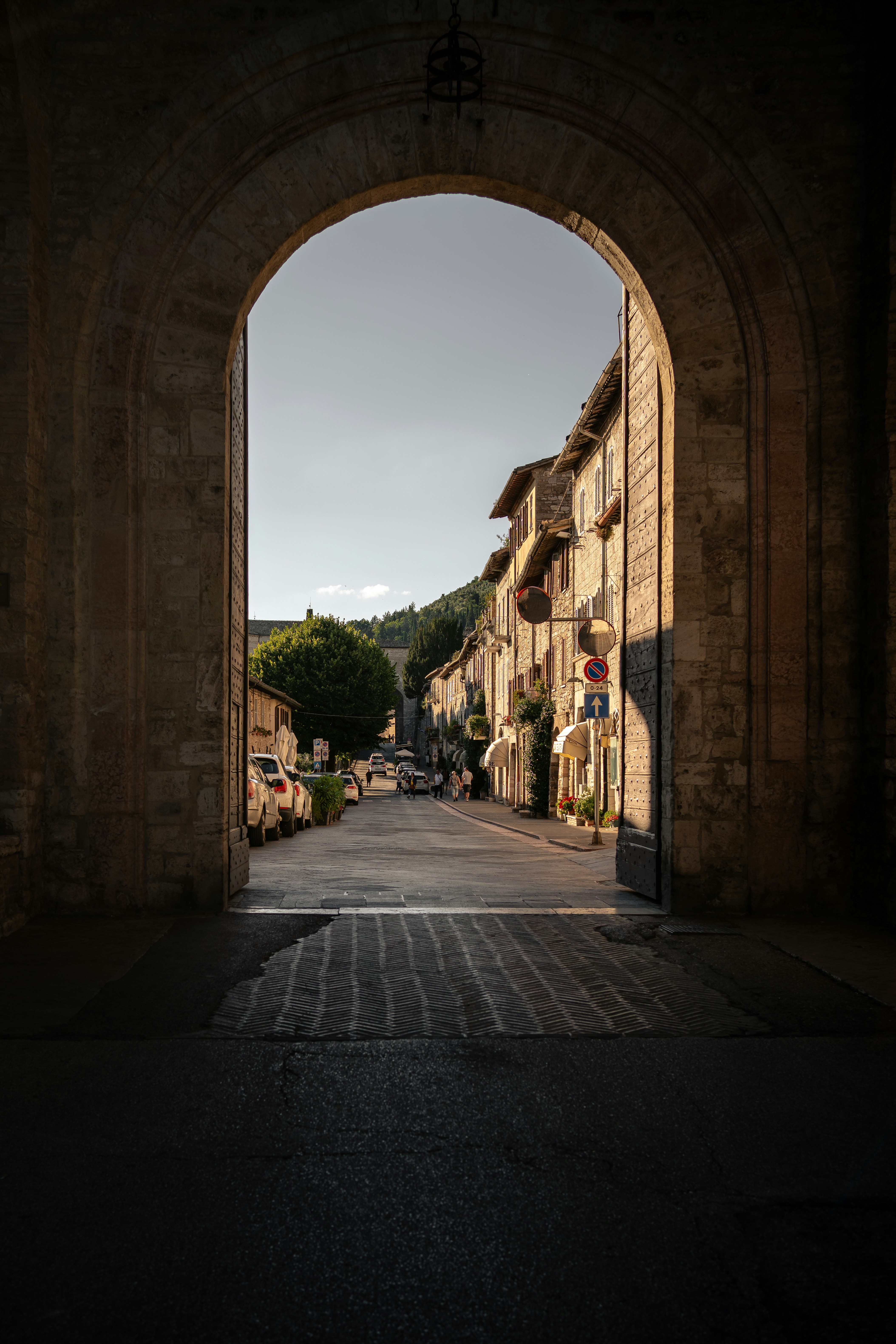 Through the Stone Gate: Sunlit Street Beyond