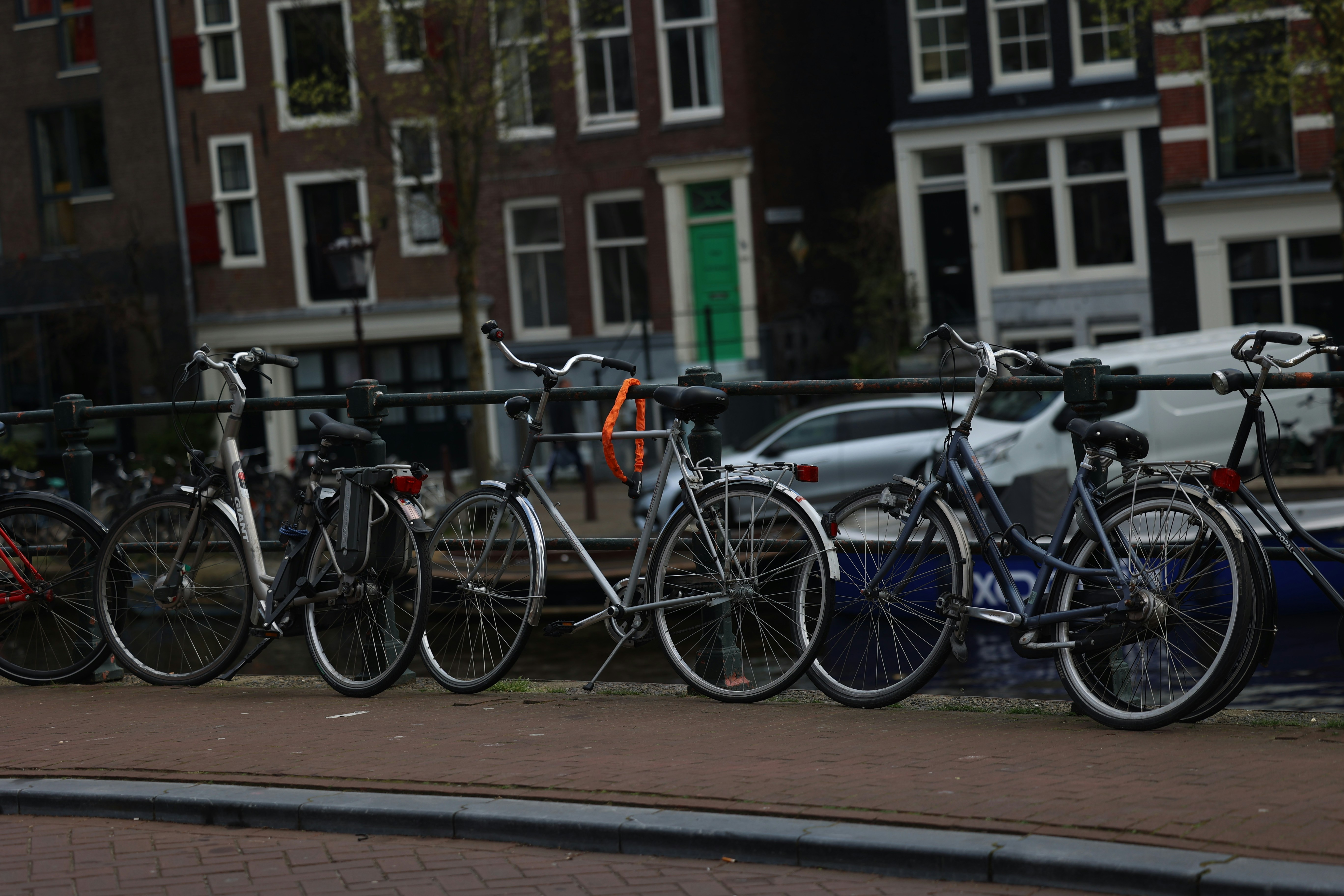 Row of bicycles by a quiet canal set against a brick street