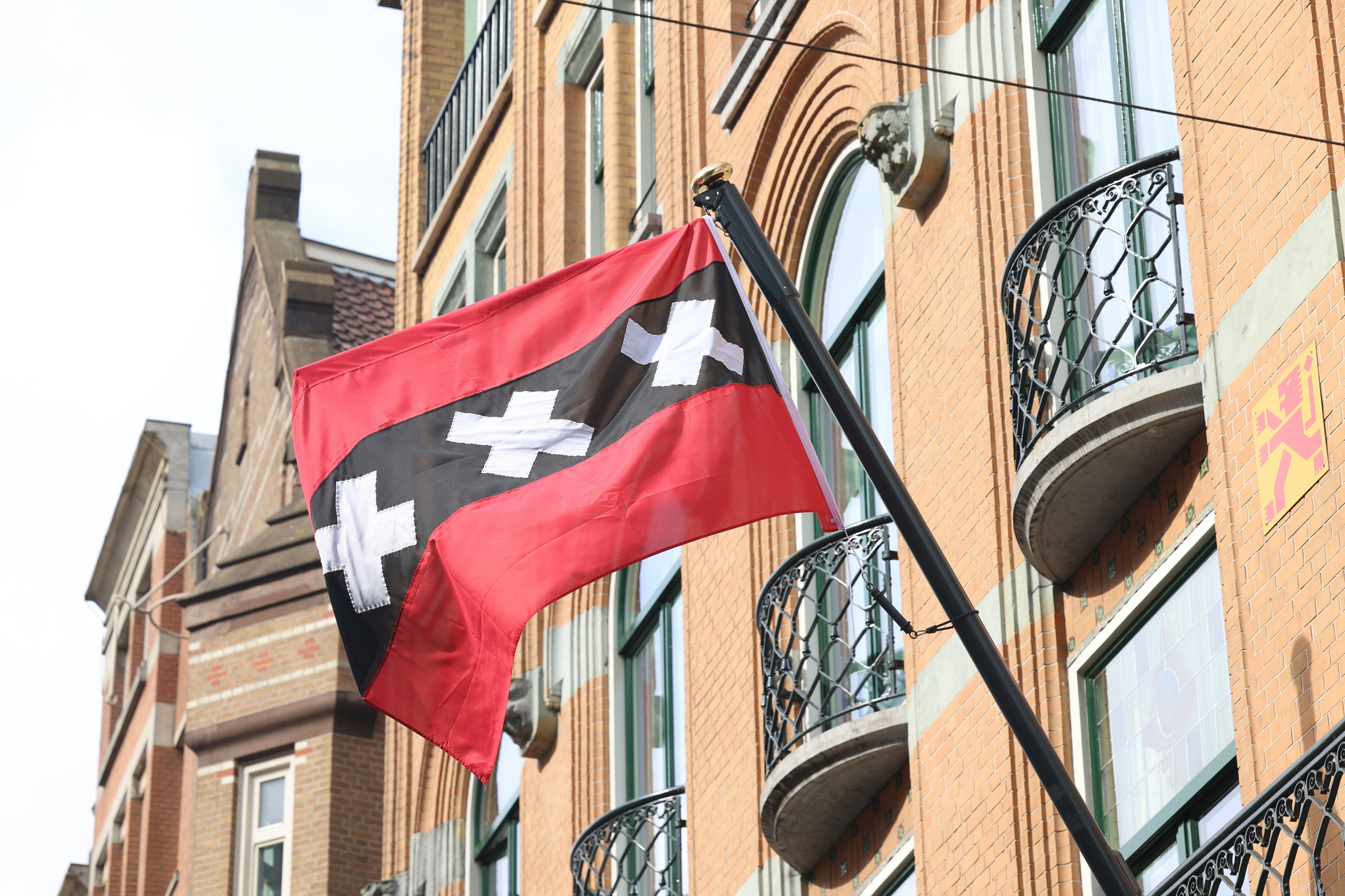 Flag of Zurich on a slanted mast against brick façades