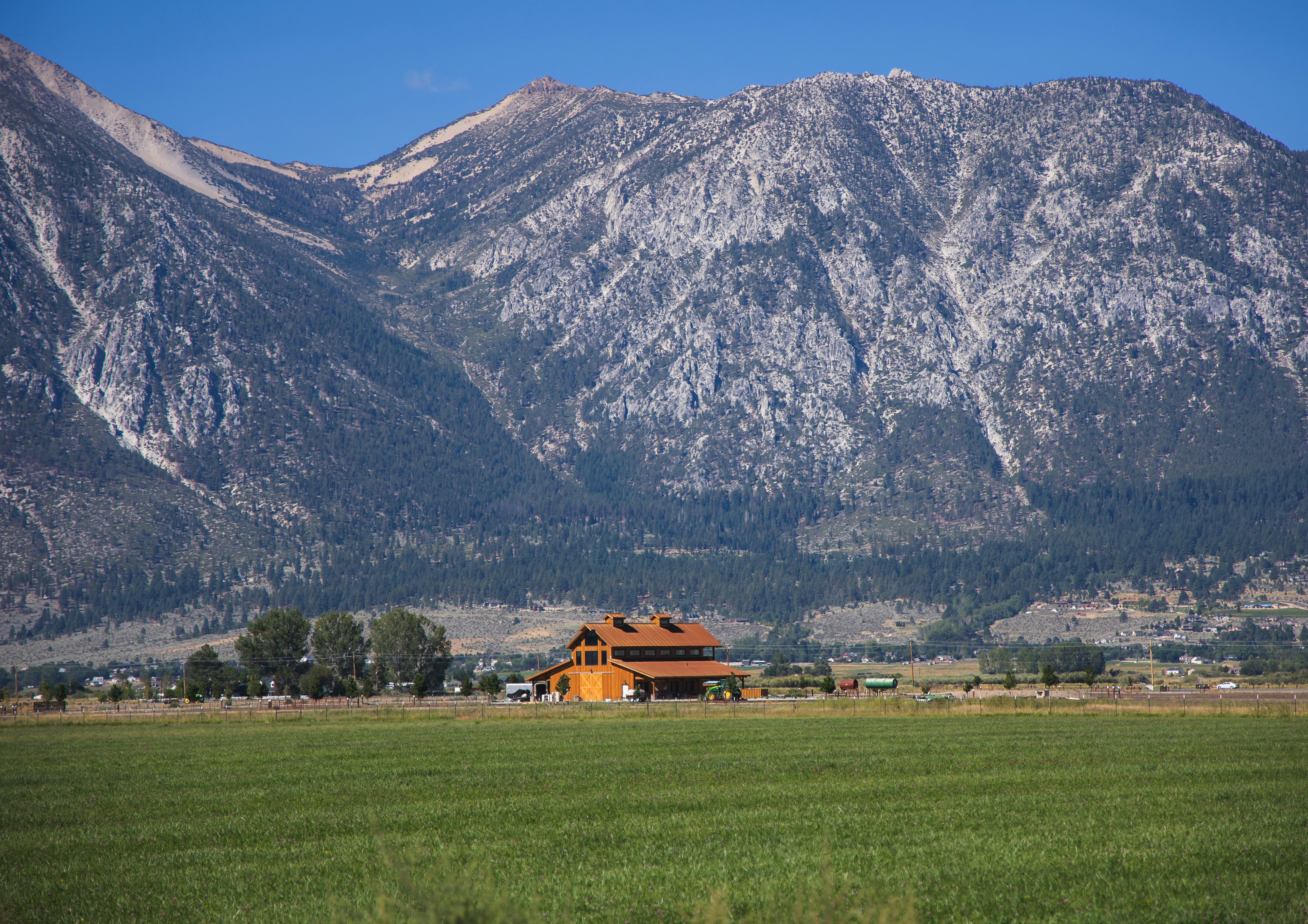 A Lone Orange Barn Nestled at the Foot of Granite Peaks