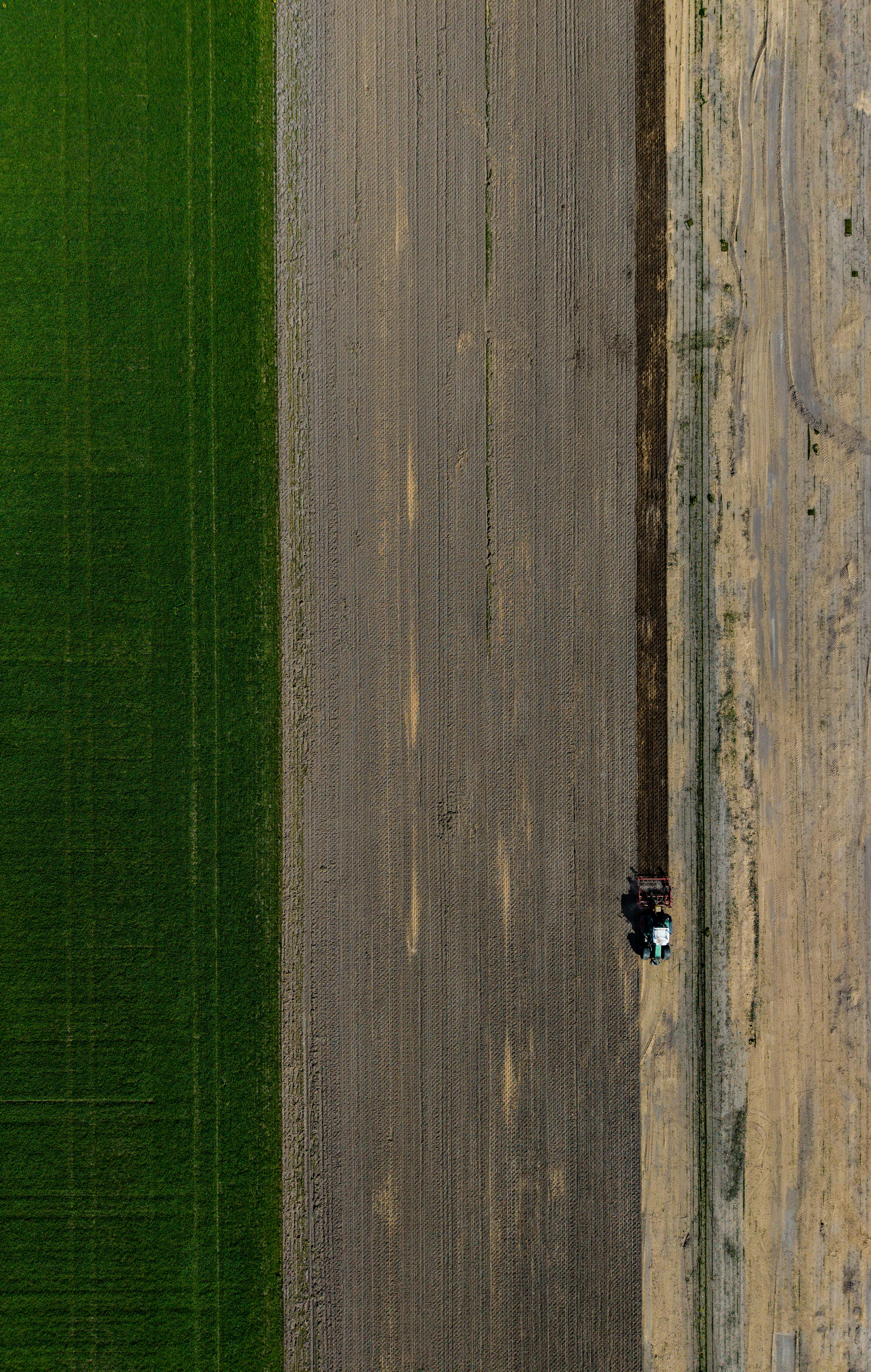 Midfield Harvest: A Single Tracked Tractor Pushing Through Segmented Fields