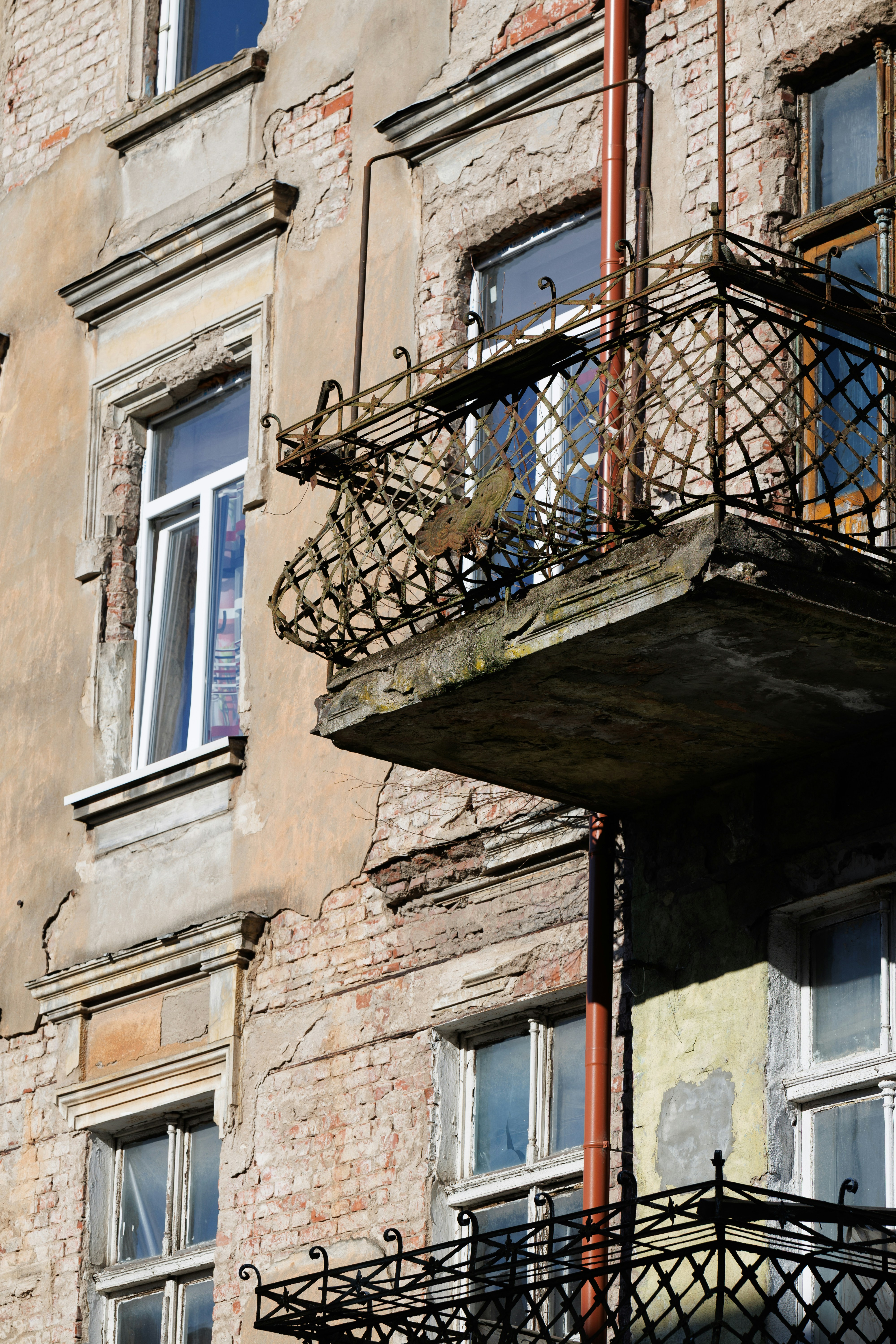 Cracked Facade, Iron Balcony: A City Tale in Brick and Rust