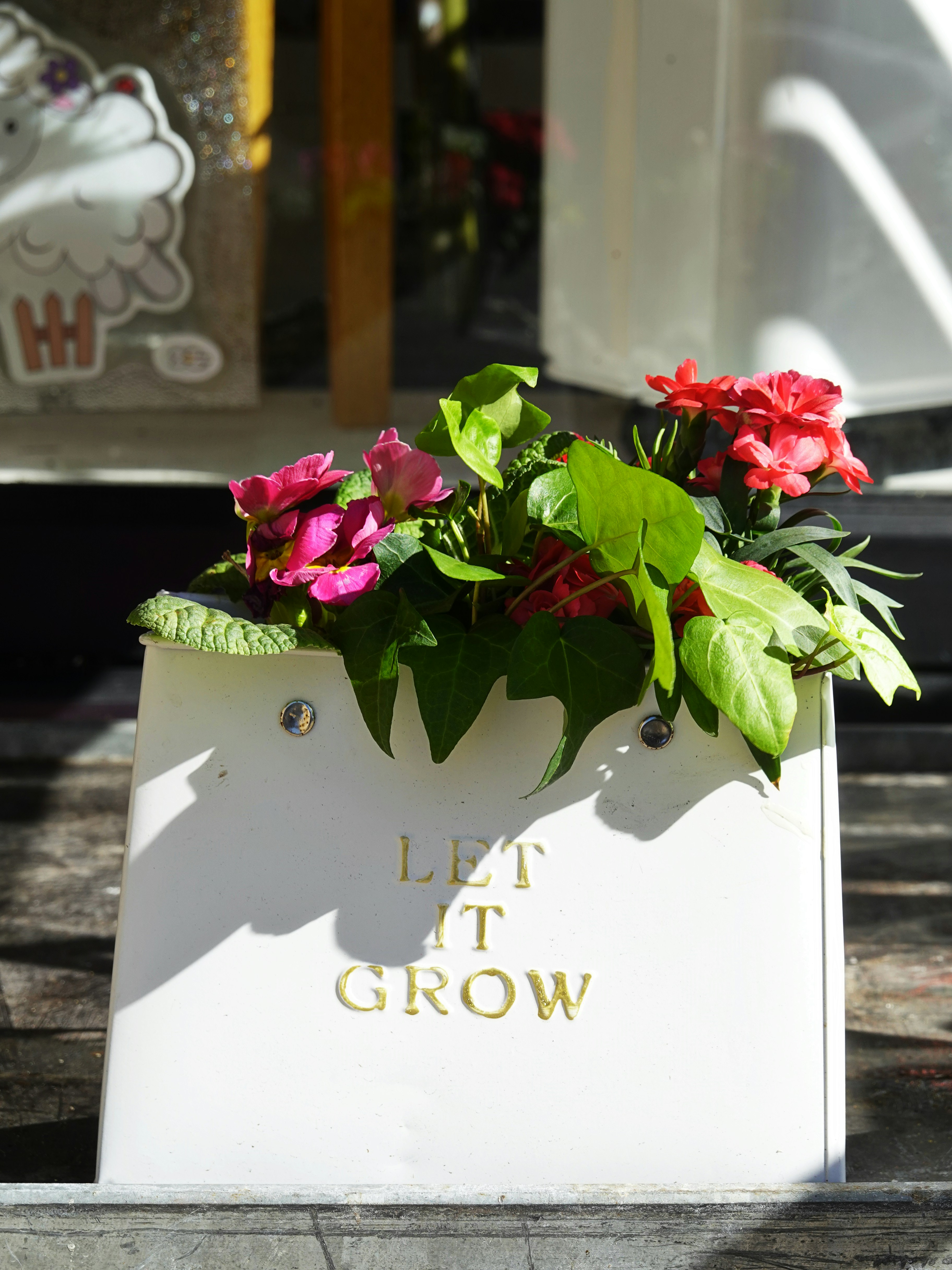 Let It Grow: A Window Box of Colorful Blooms Over a White Planter