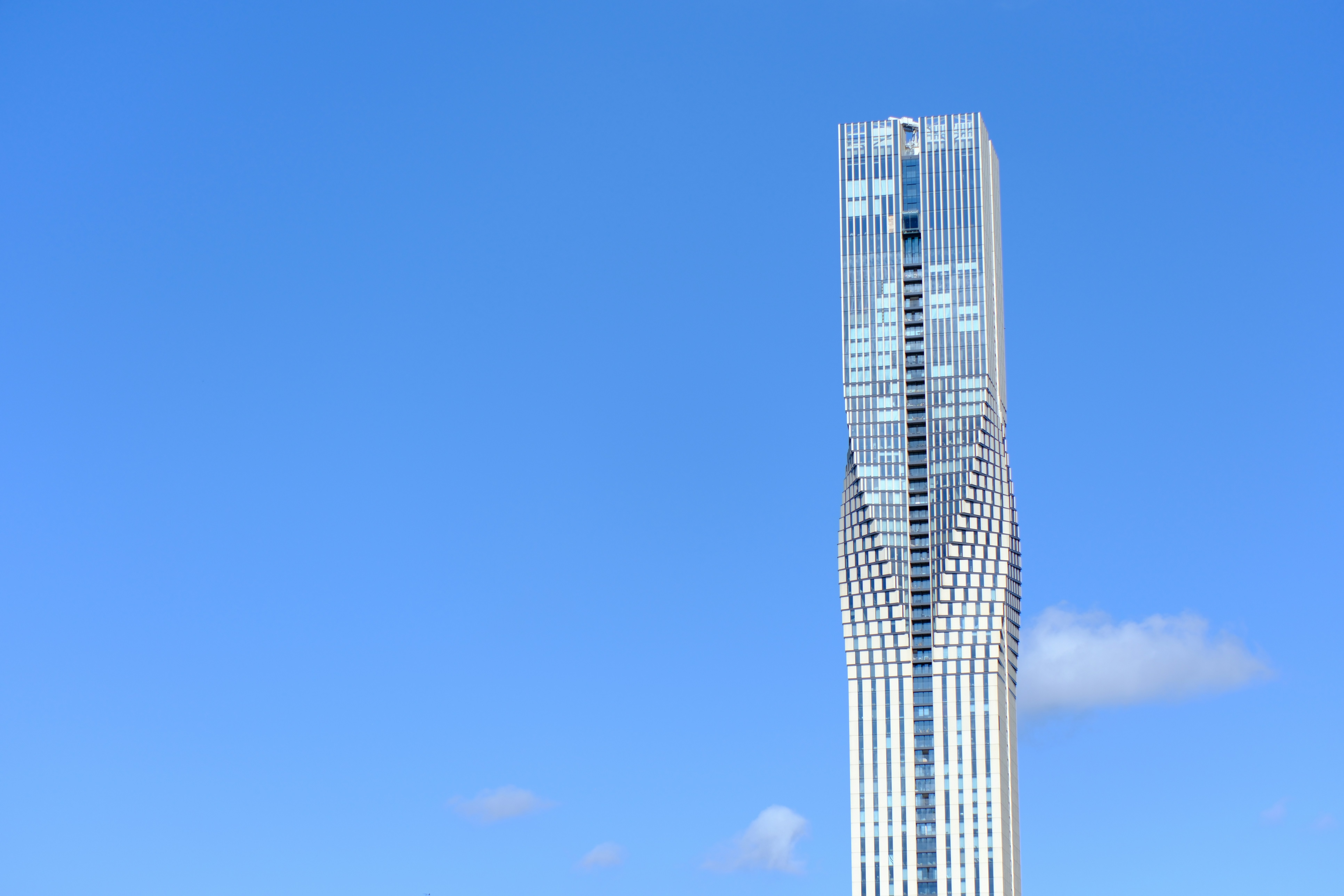 Skyward Prism: A Sky-Blue Tower Pierces the Horizon
