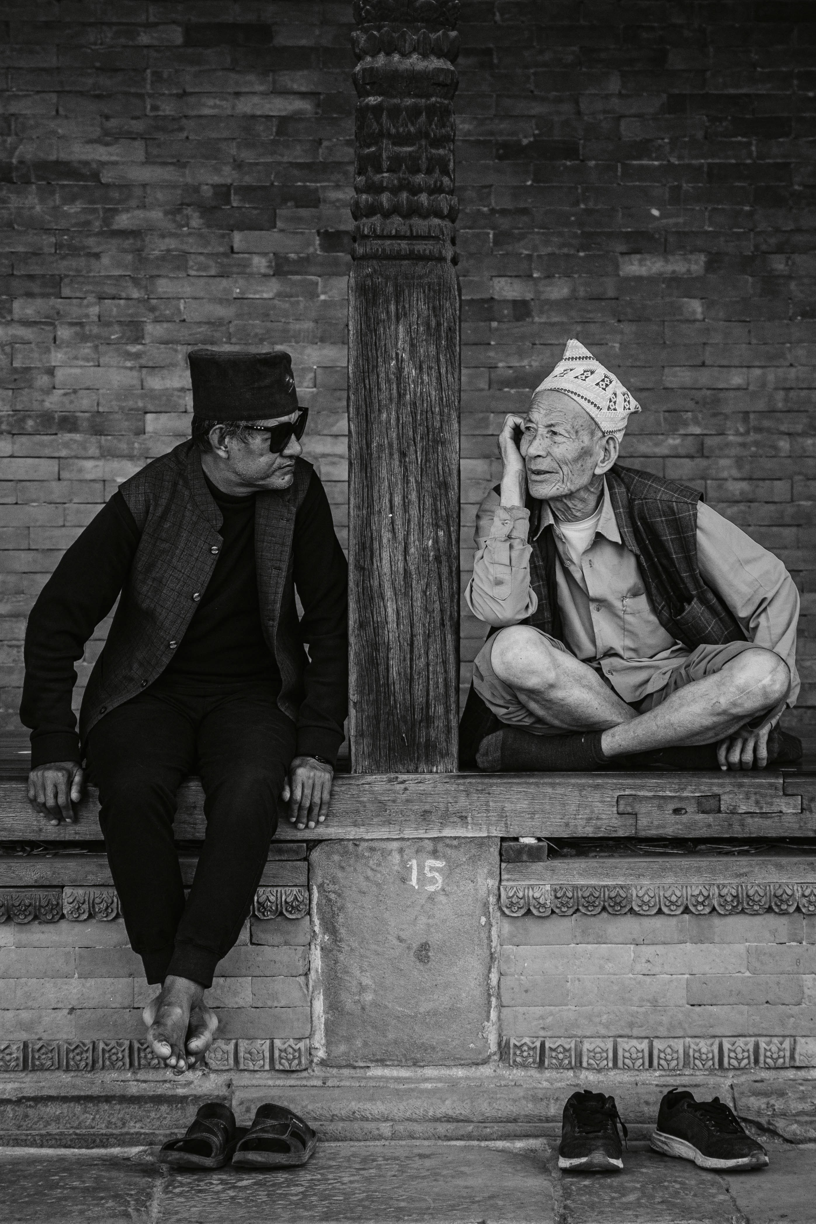 Conversing Across Time: Two Elders Share a Quiet Moment on the Stone Balcony
