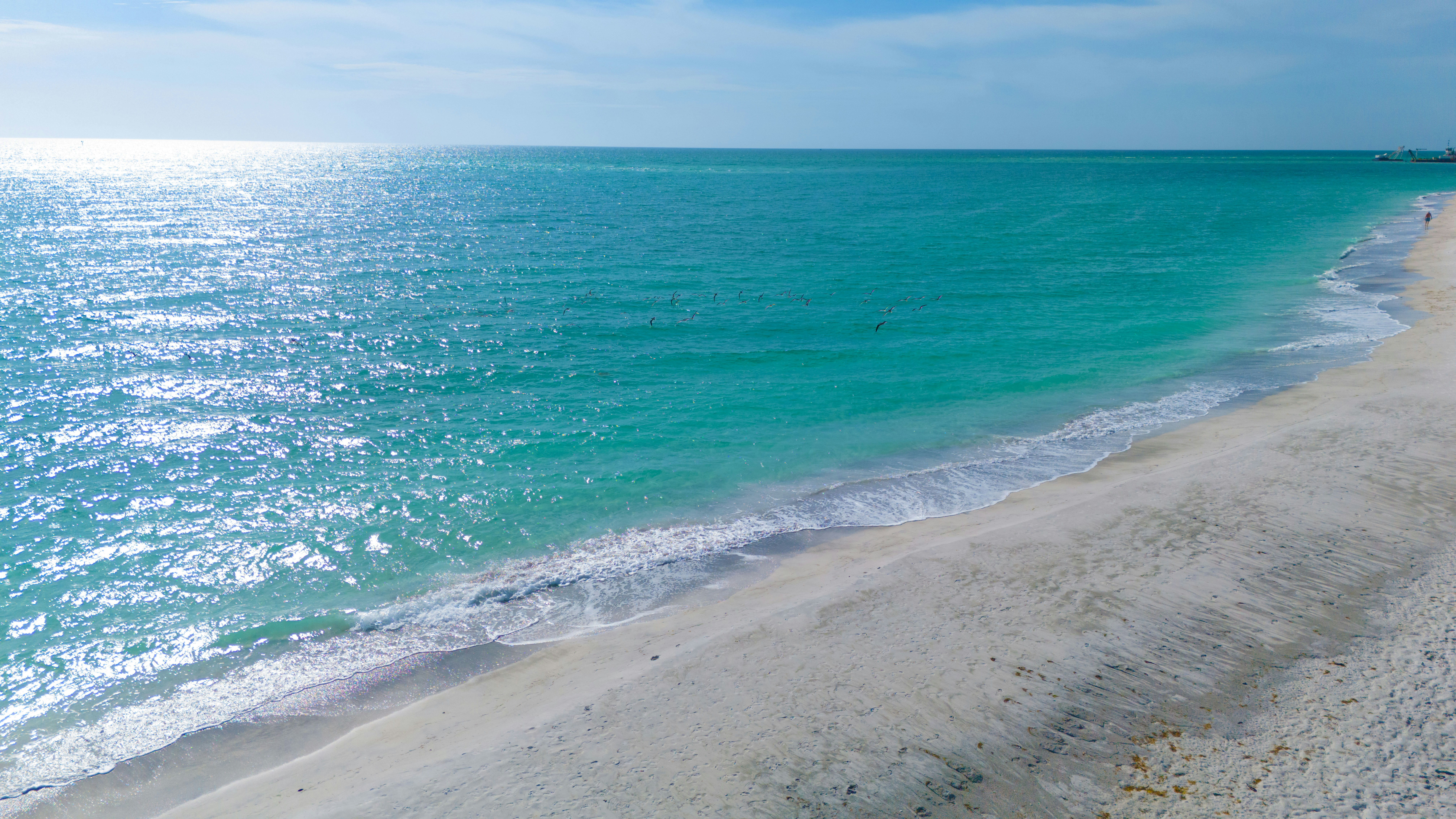 Sunlit Diagonal: A Quiet Seashore Walk along Turquoise Waters
