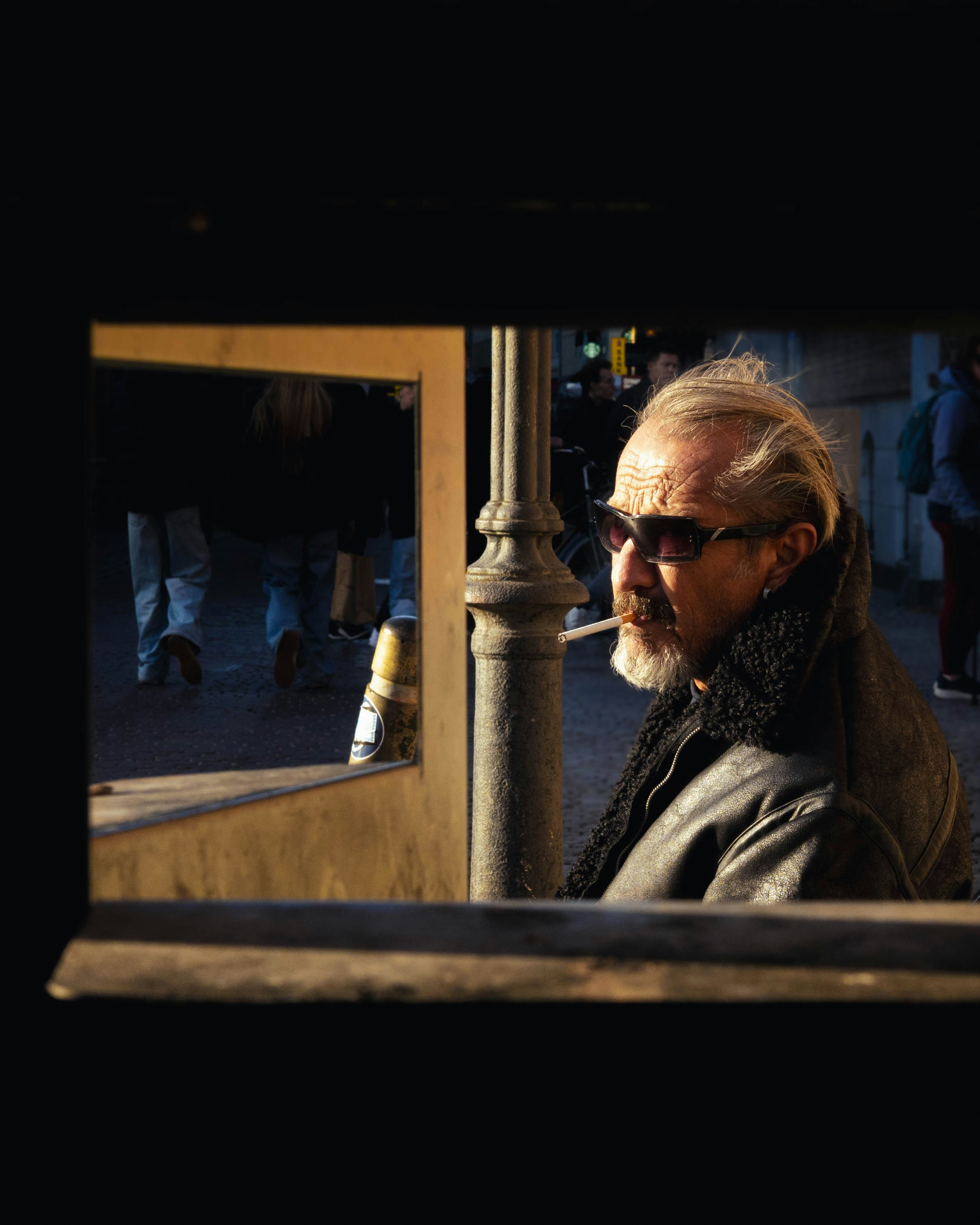 Smoke and Steel: The Street Portrait Through the Divider of a Window