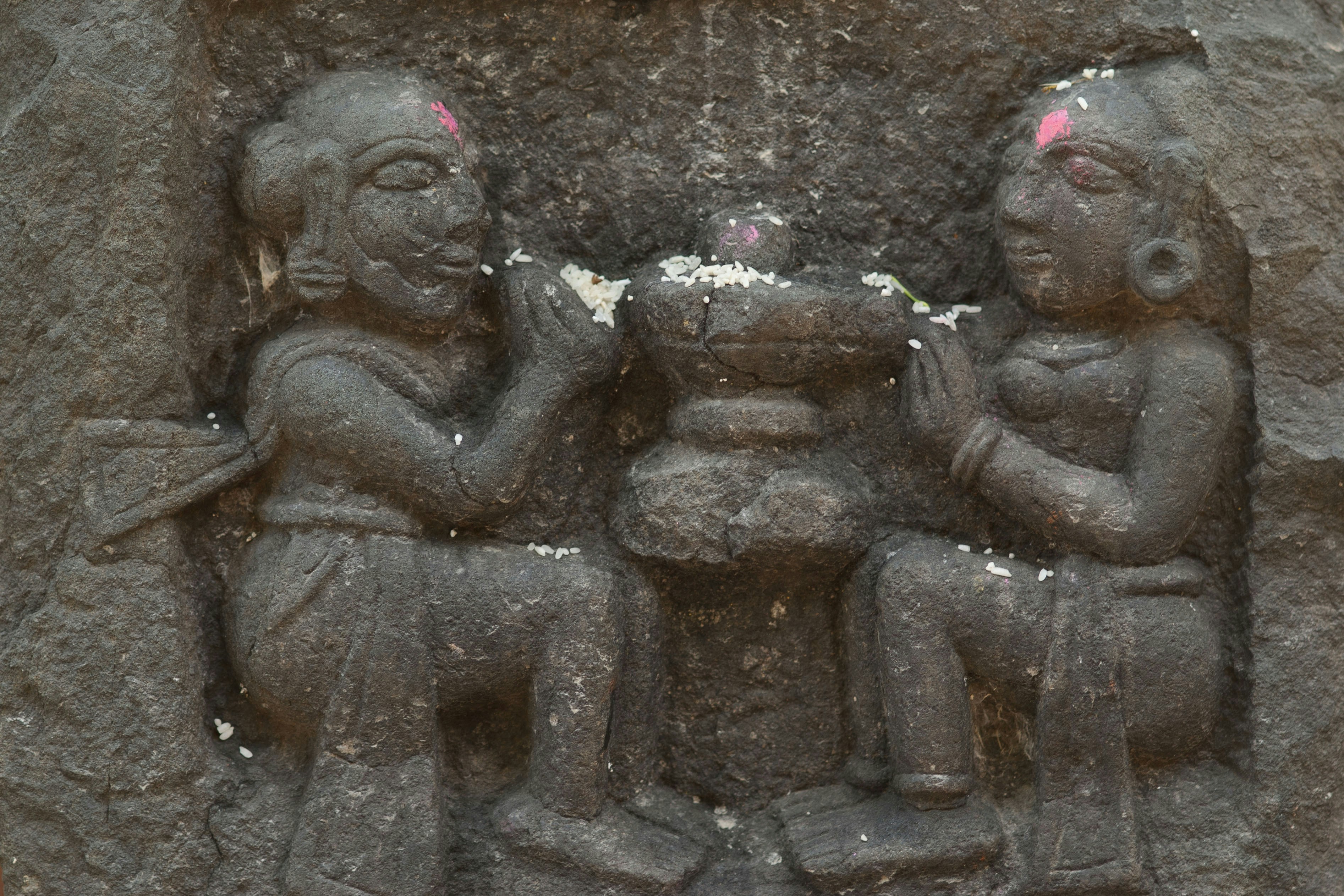Two Figures Offering a Sacred Bowl in Weathered Stone