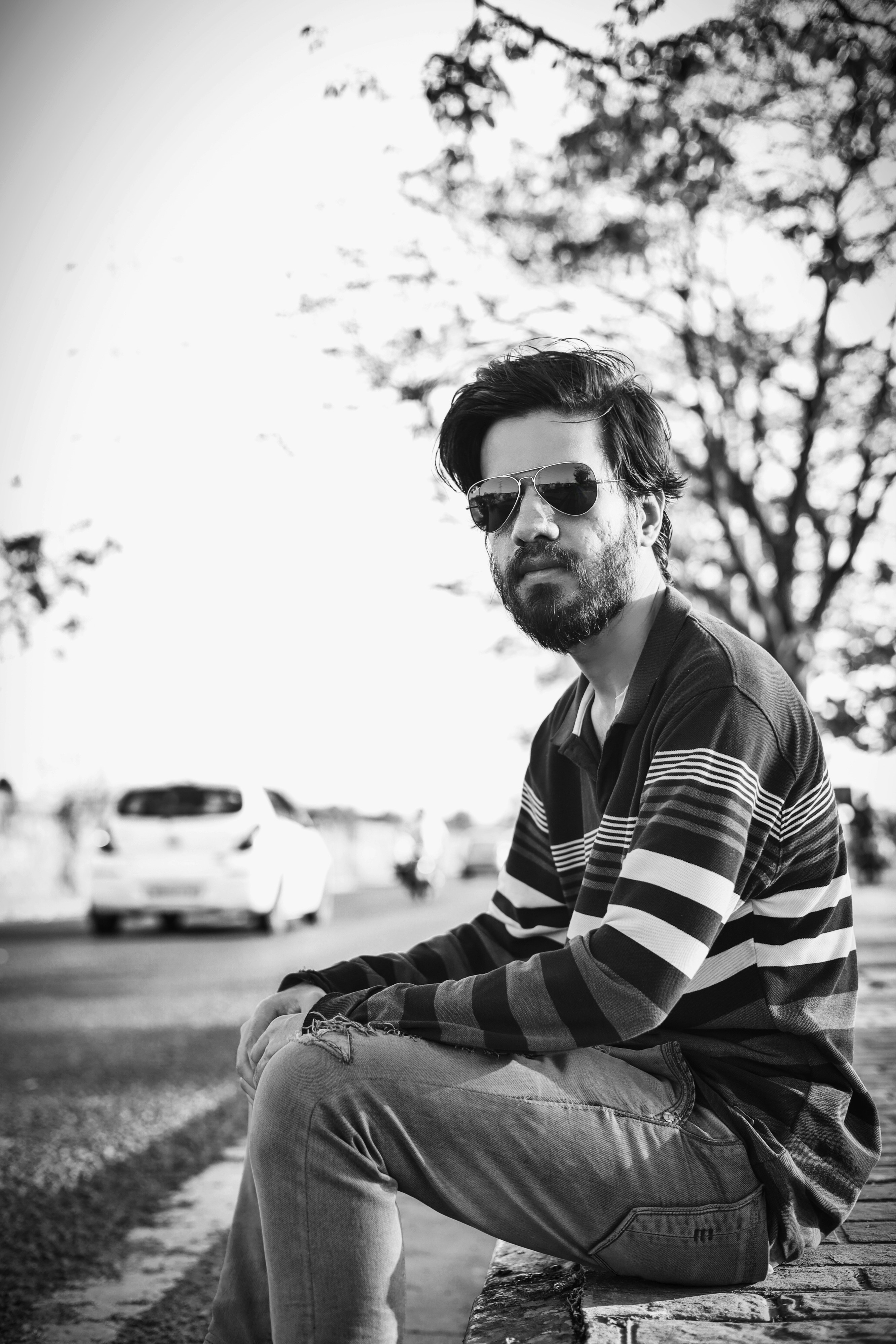 Sunglassed Quietude: A Pensive Moment on the Park Bench