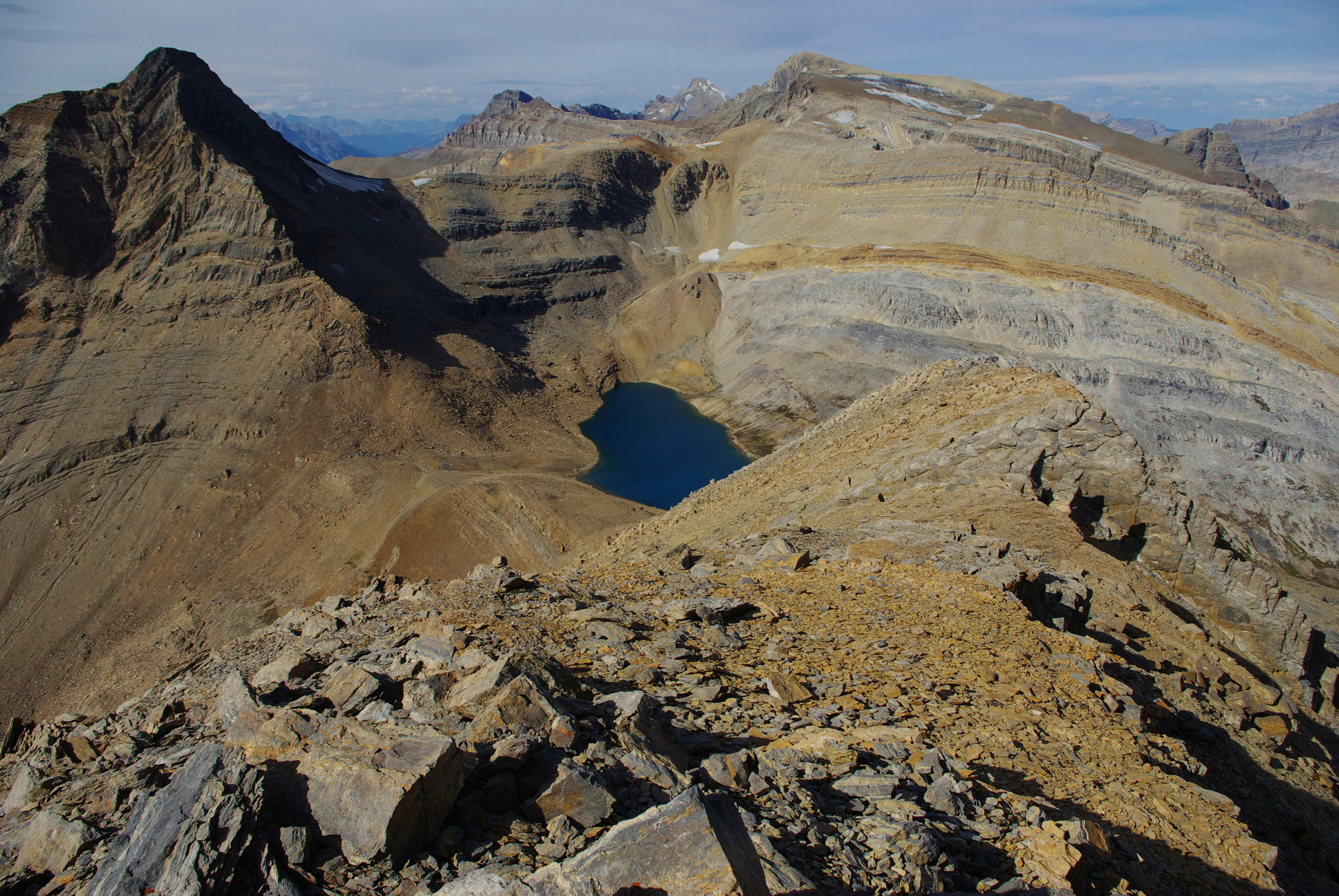 Luminous Canyons: A Tapestry of Strata and a Hidden Alpine Pool