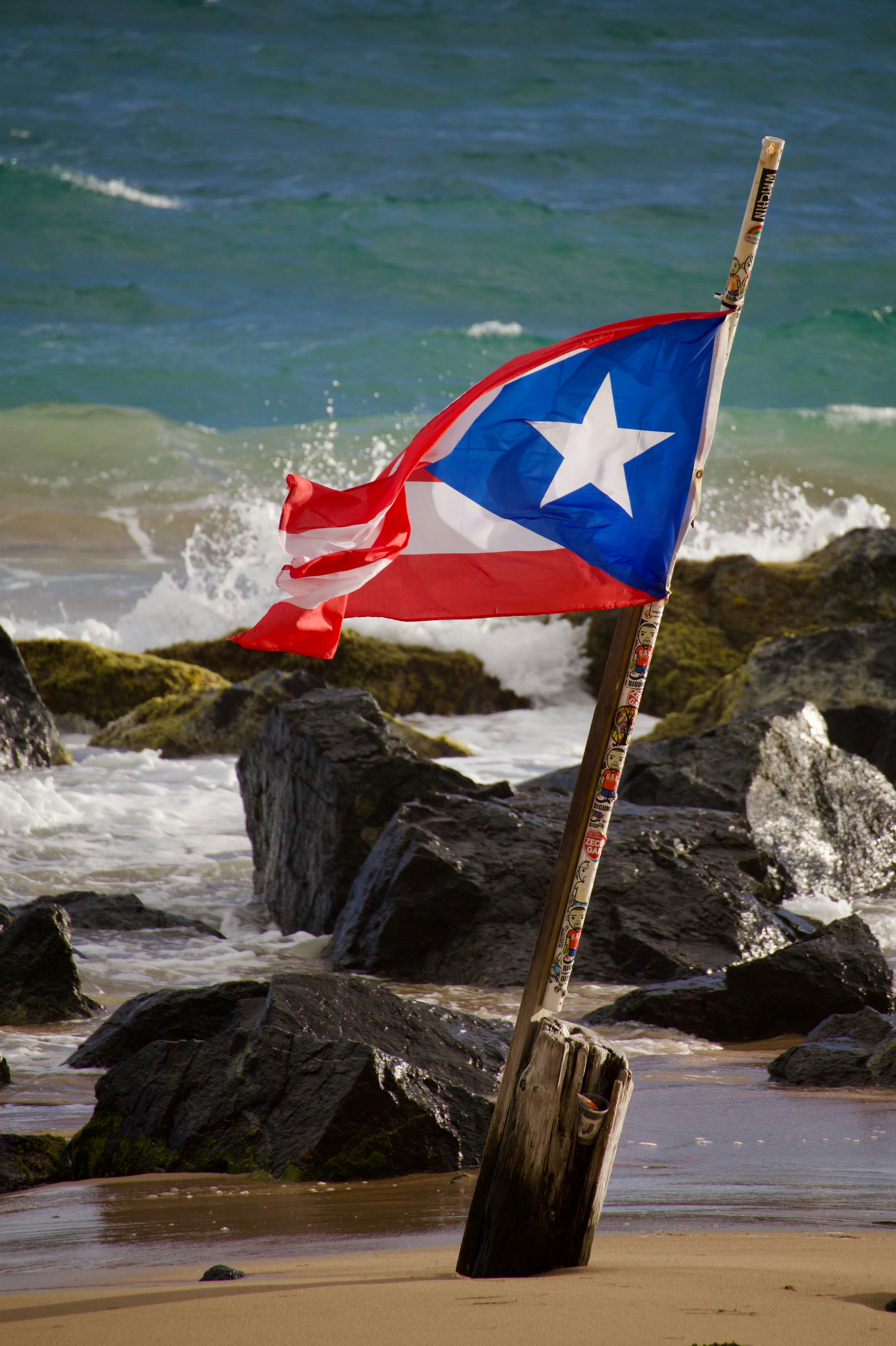 Flag on the Sea-Rim: A Lone Puerto Rican Banner among Weathered Rocks