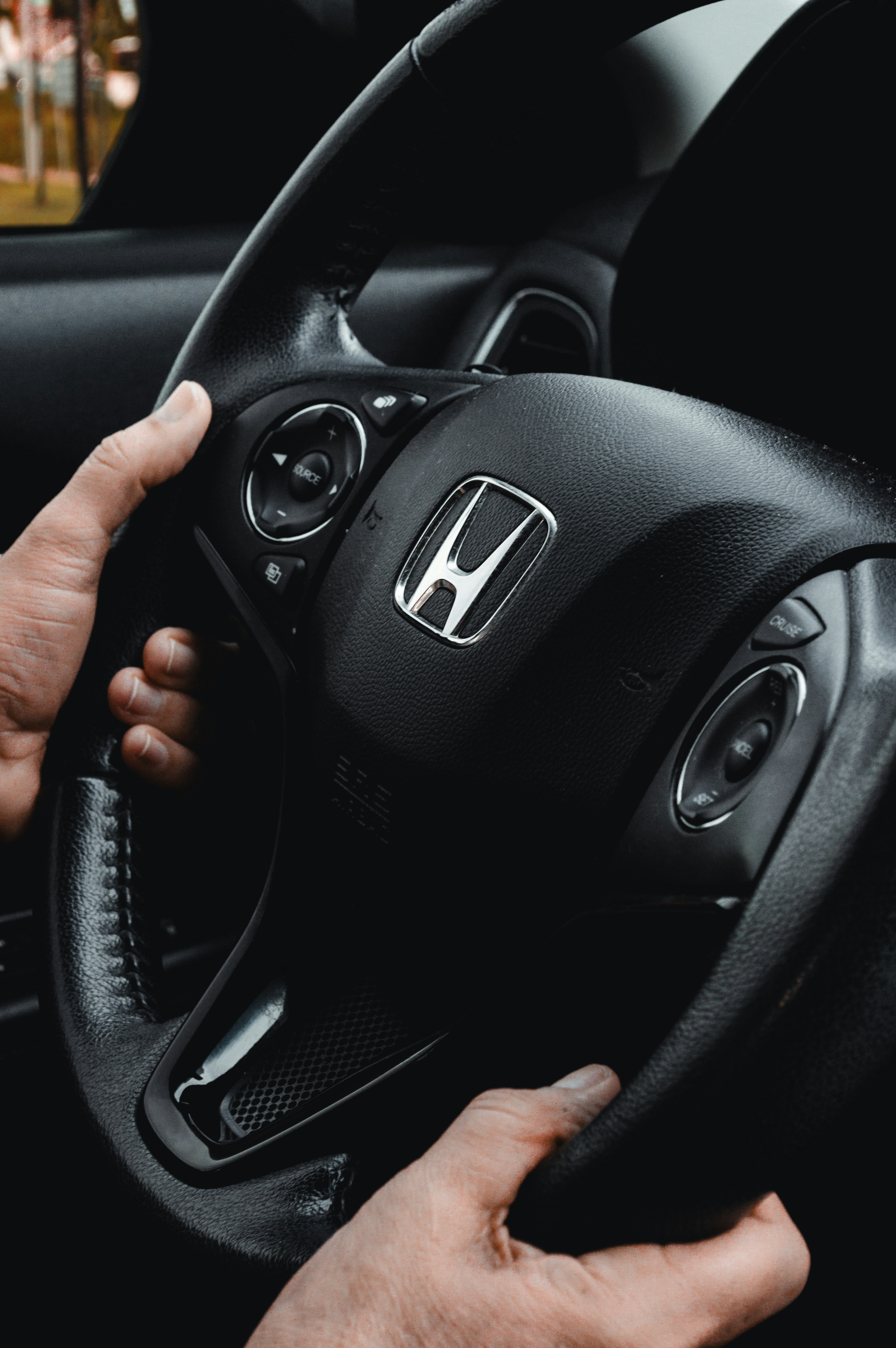 Hands on the Wheel: A Honda emblem and steering detail