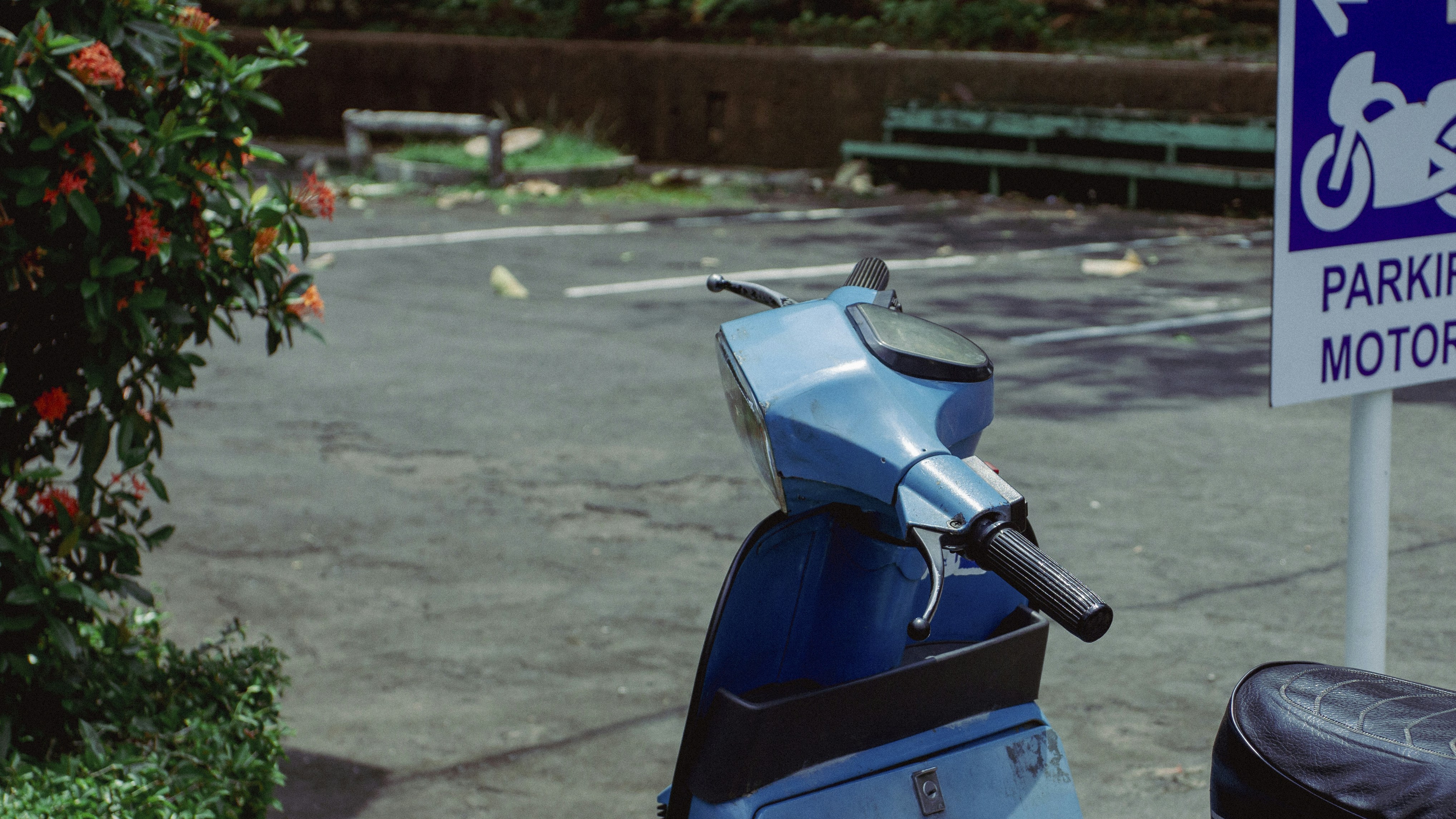 Blue Vespa at the Edge of the Parking Lot