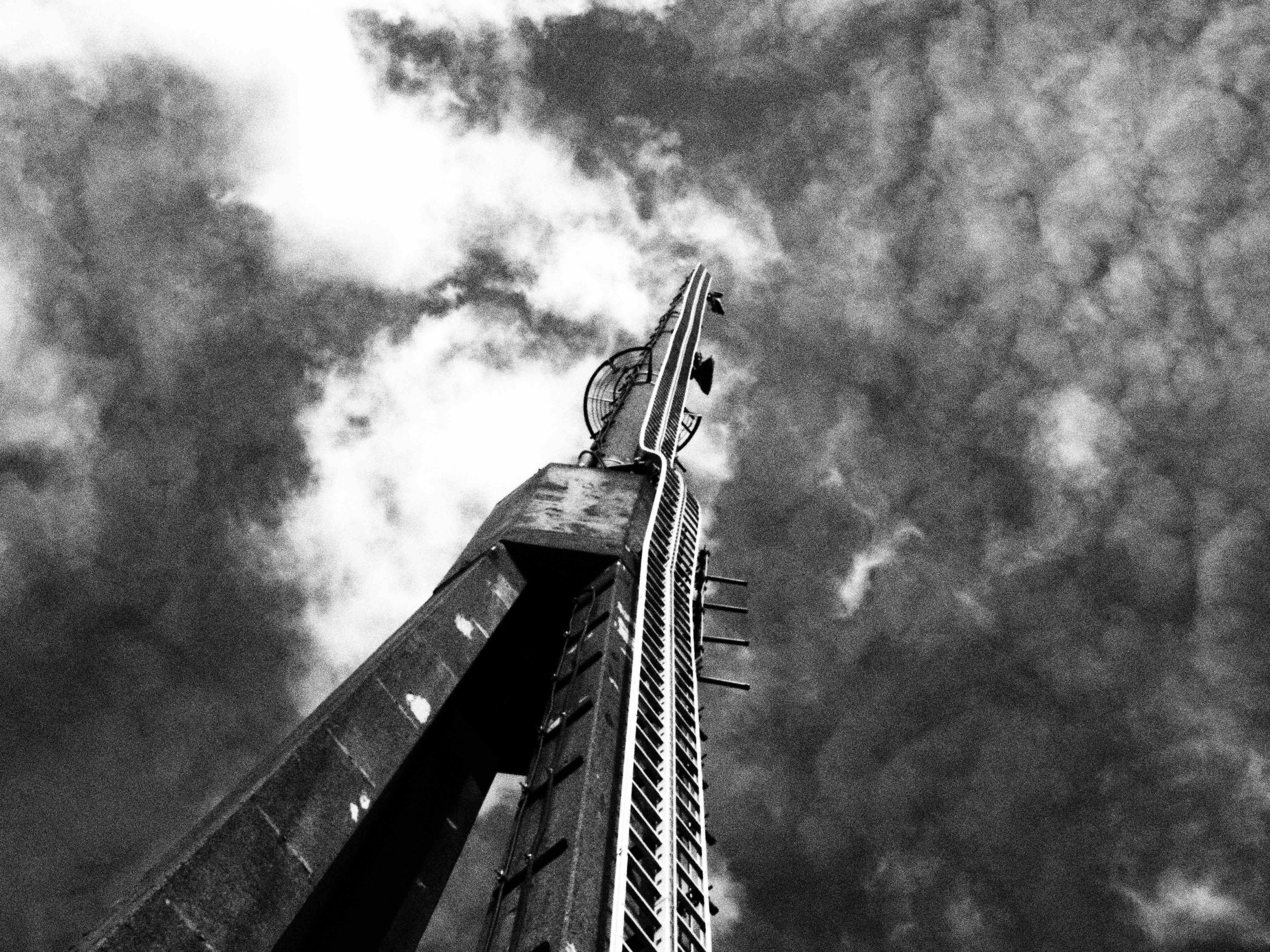Lightning-Tower Silhouette: Monochrome Metal Against Grainy Skies
