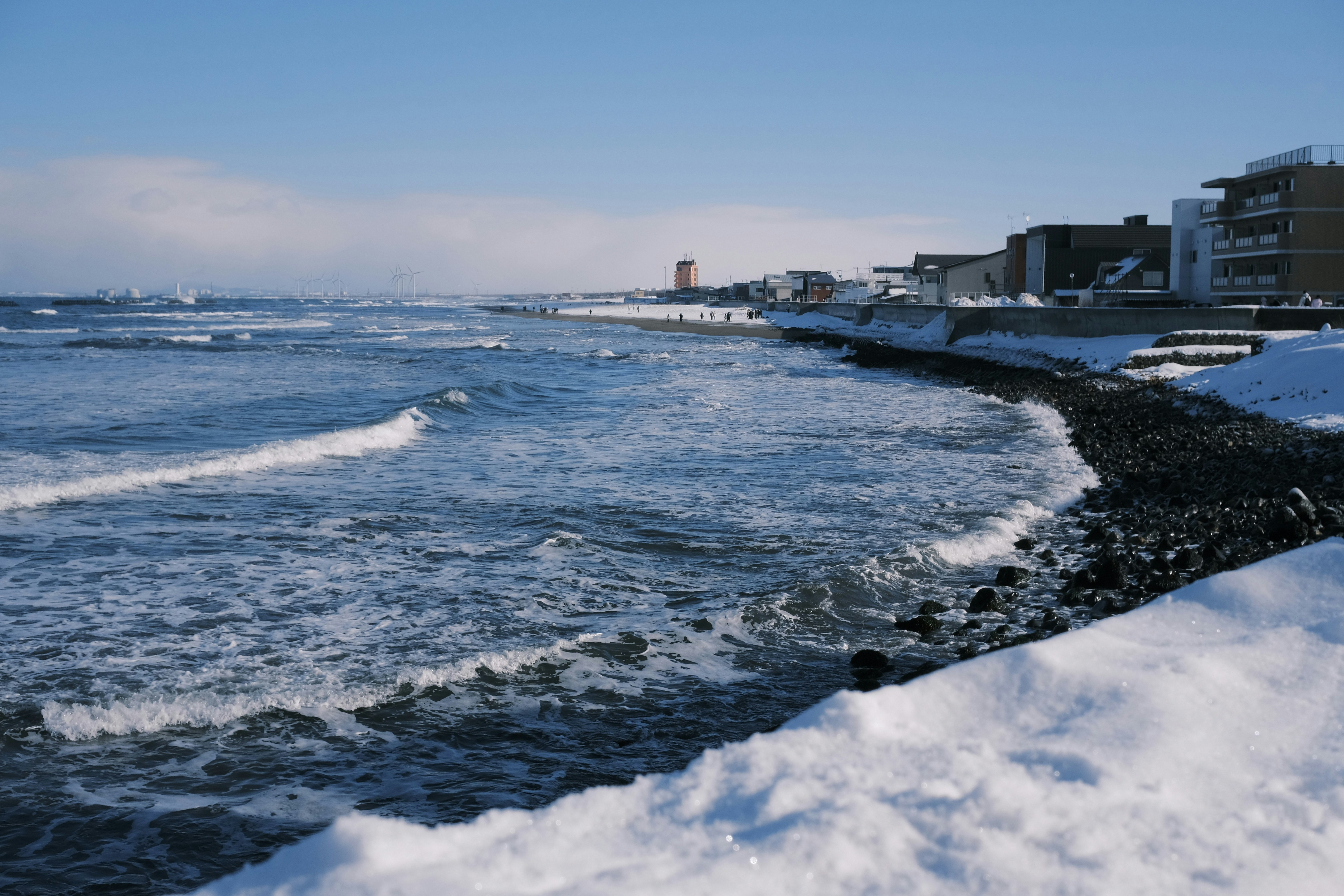 Snow-kissed coastline under a crisp winter sky