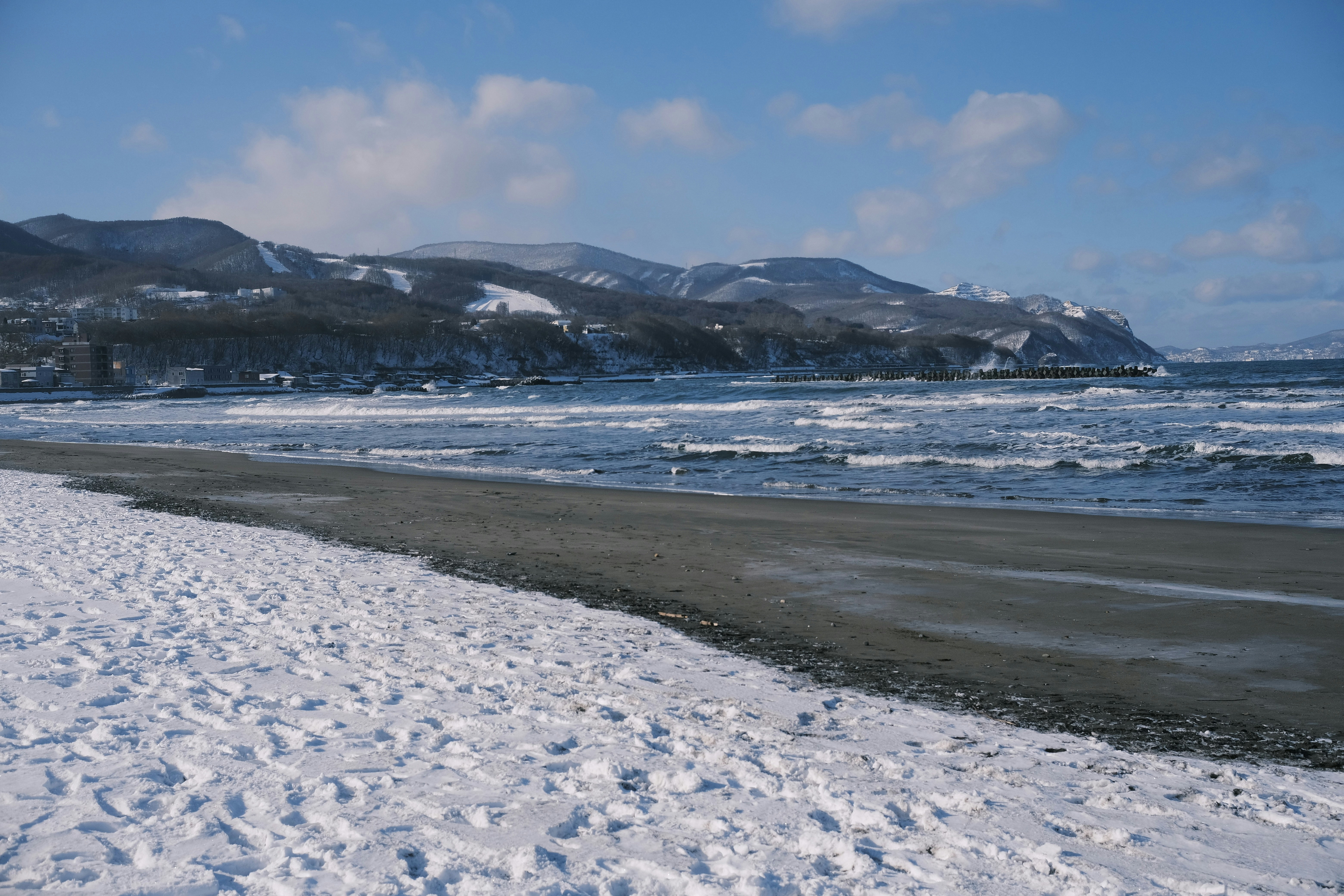 Snow-Capped Beach Under a Bright Coastal Sky