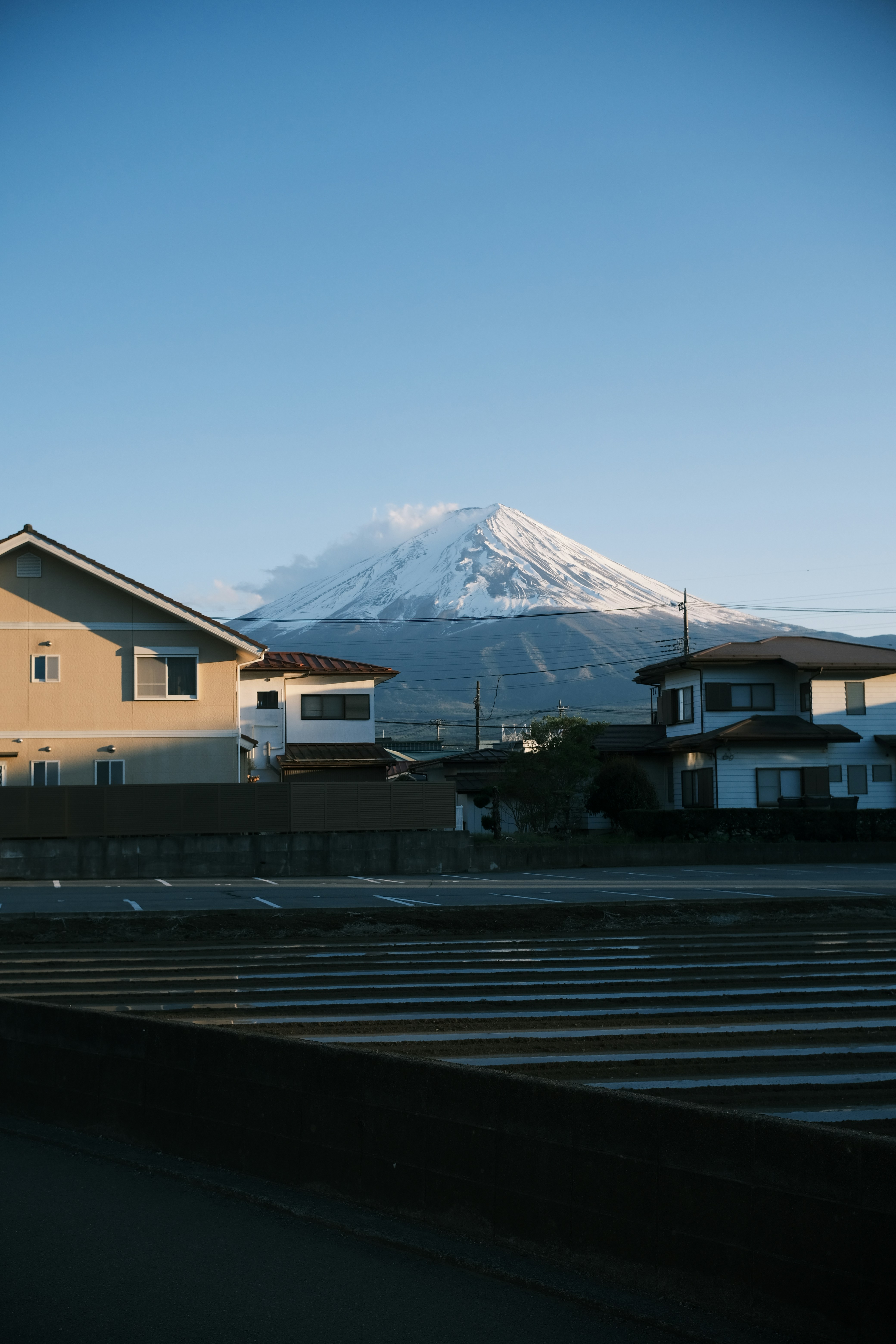 Snow-Capped Volcano Over Quiet Suburban Street at Dusk