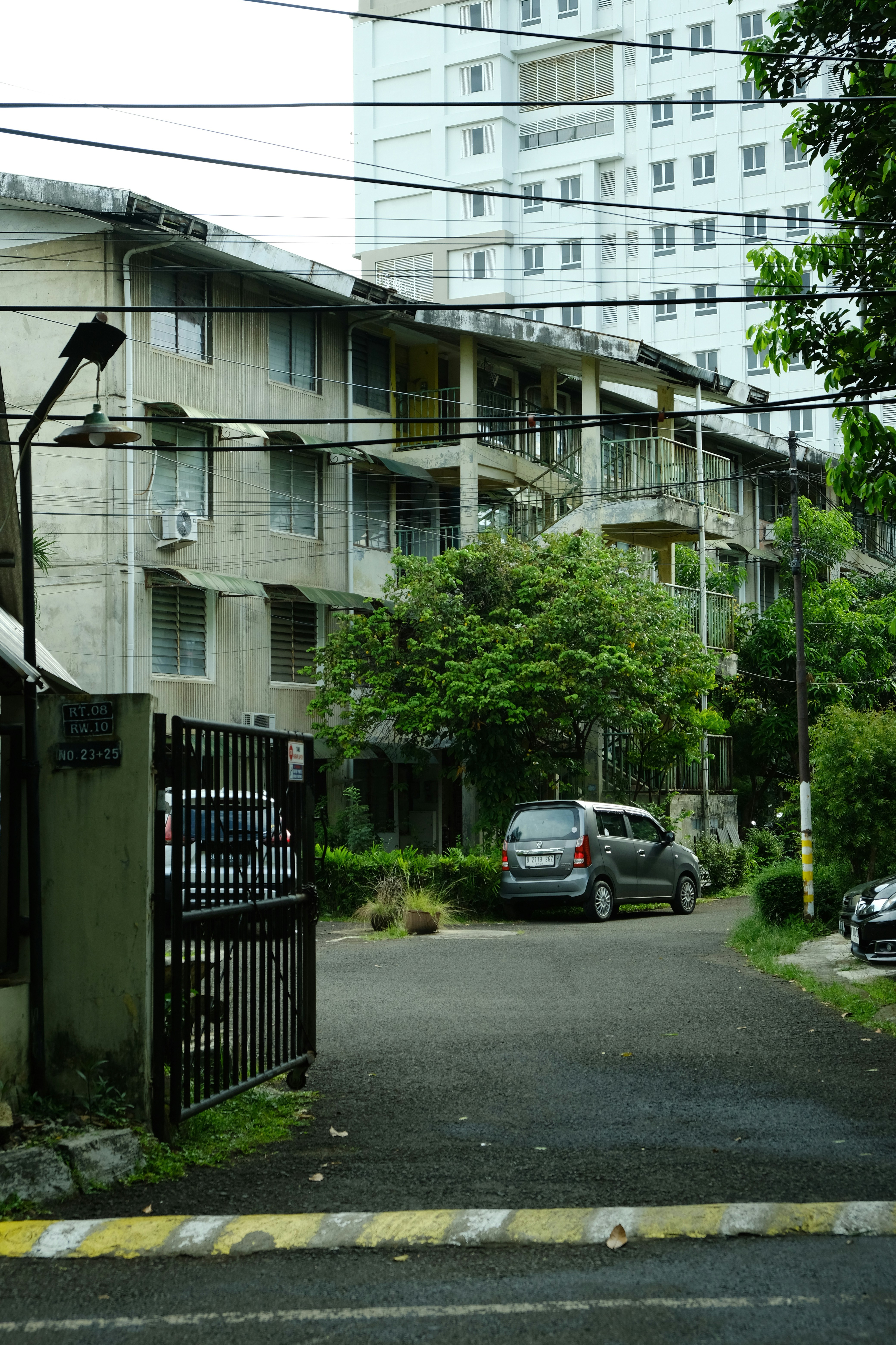 Urban Courtyard Echoes: A Quiet Drive Past a Weathered Apartment Block