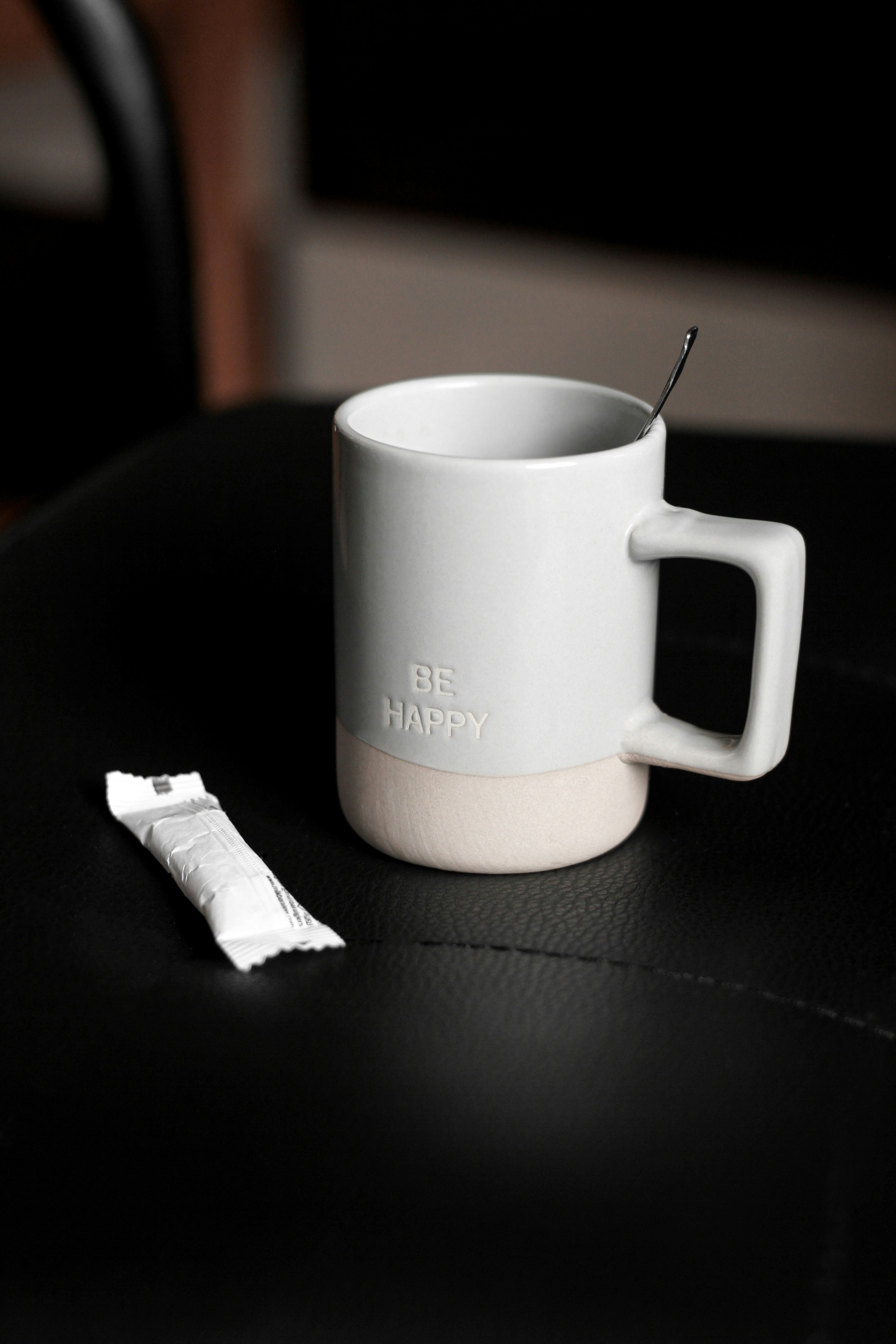 Minimalist morning: a mug and sugar packet on a shadowed table
