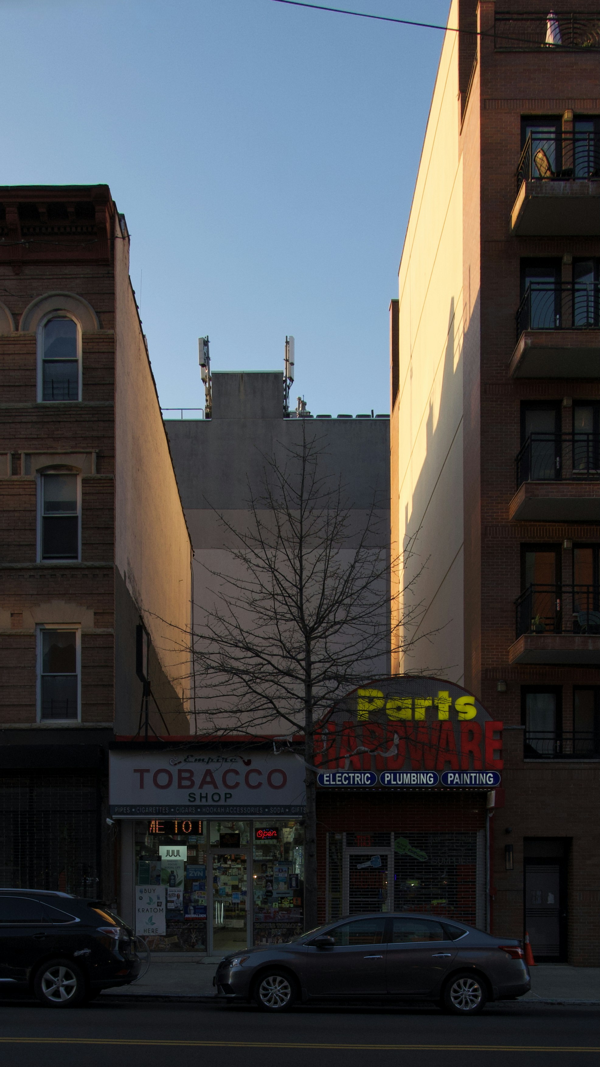 Sunlit Facades and Neon Signs: Street Scene in Evening Light