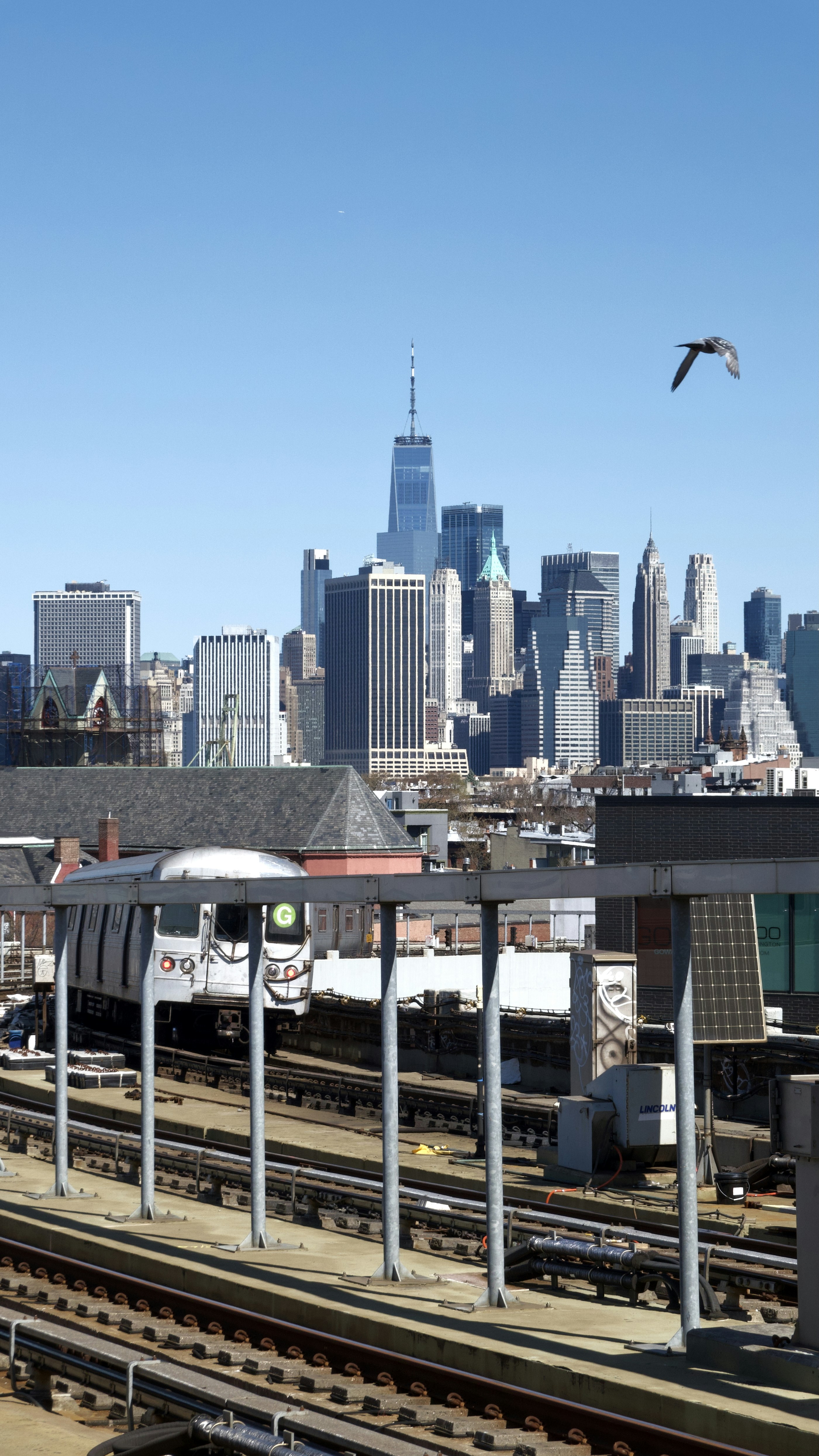 Cityscape Over Rails: Skyline and Commuter Line Under a Clear Sky