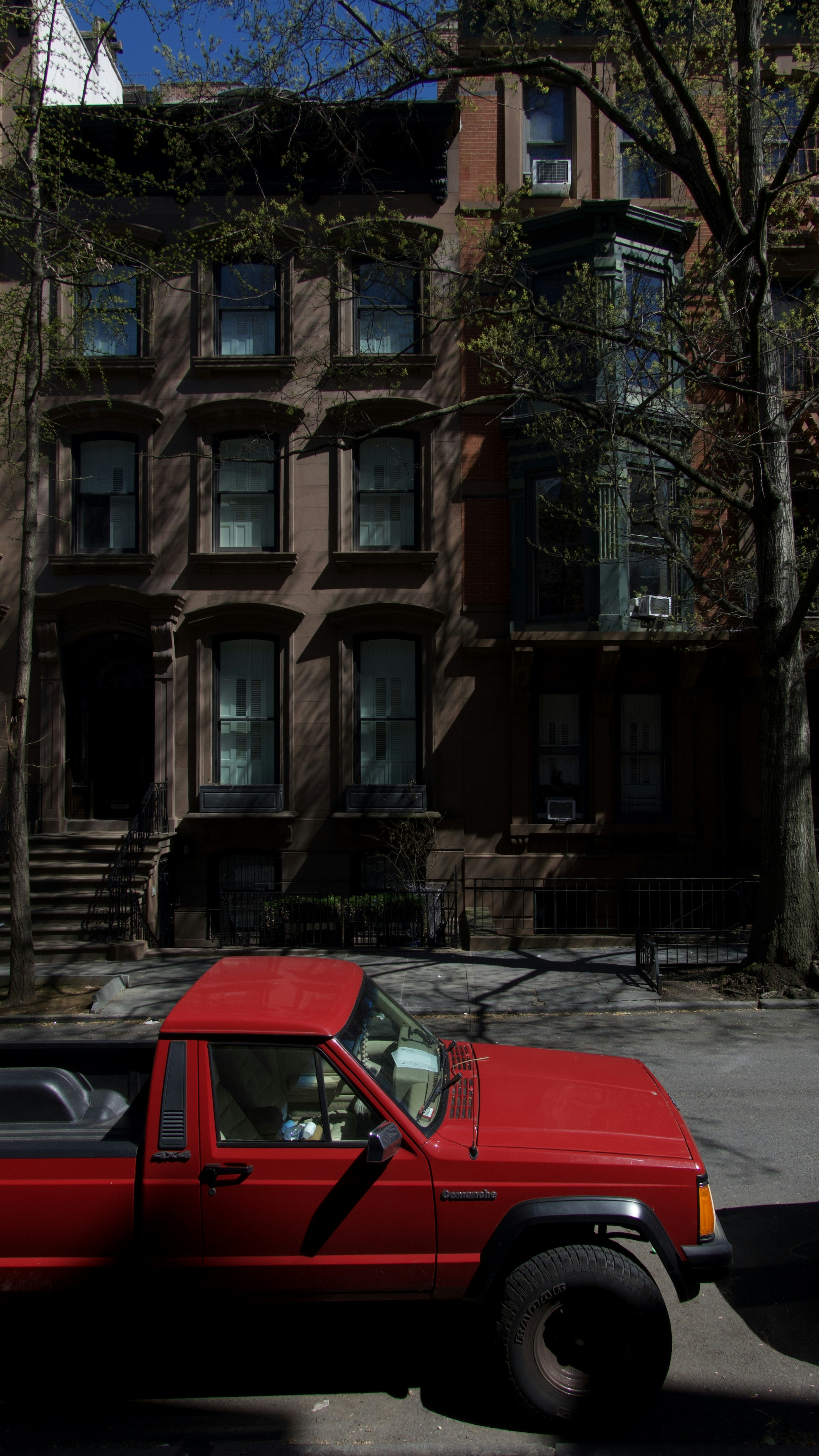 Red Pickup at Dusk: An Urban Facade with a Bold Crack of Color