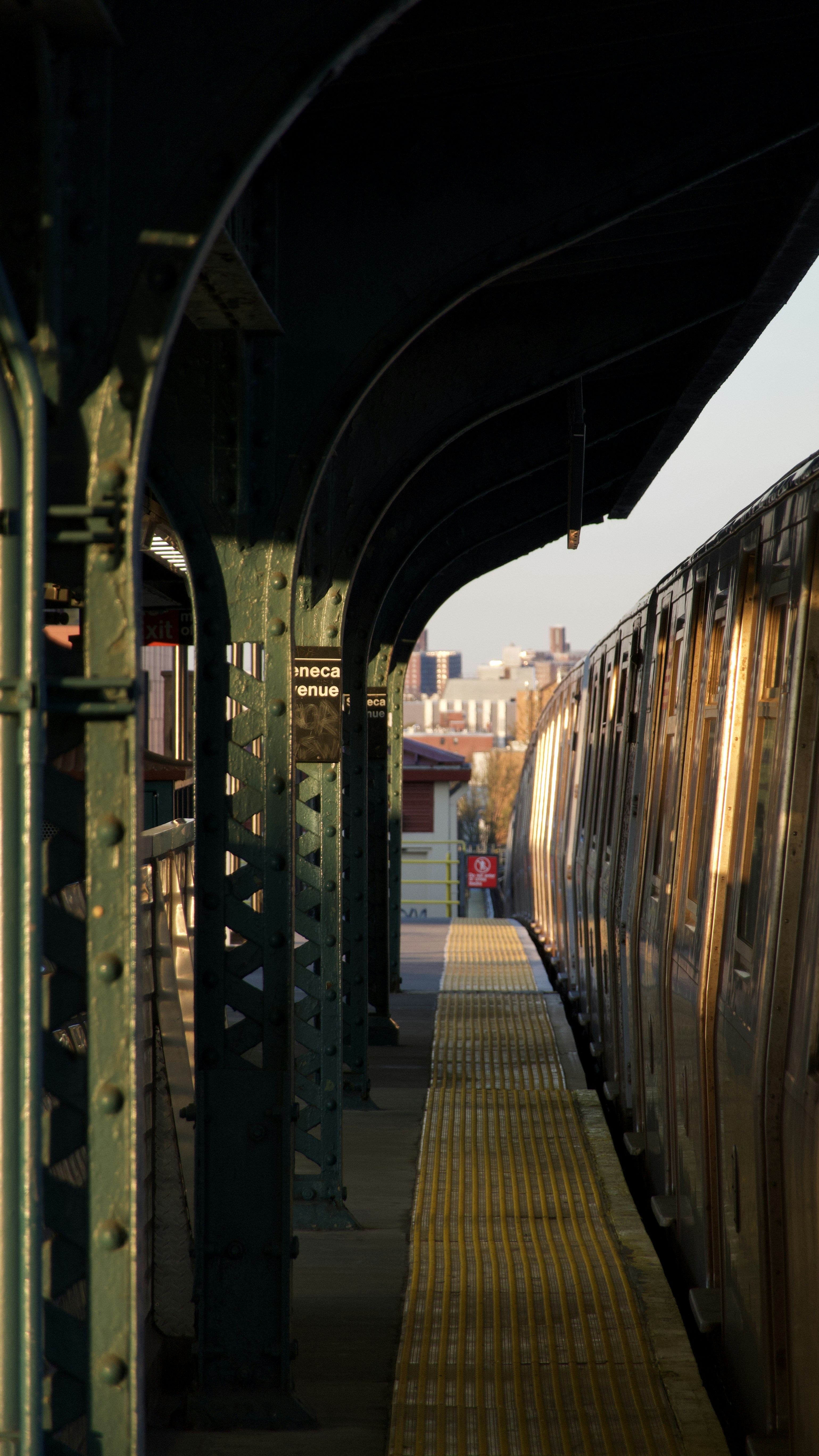 Steel Arches and Sunset Train at a Quiet City Platform