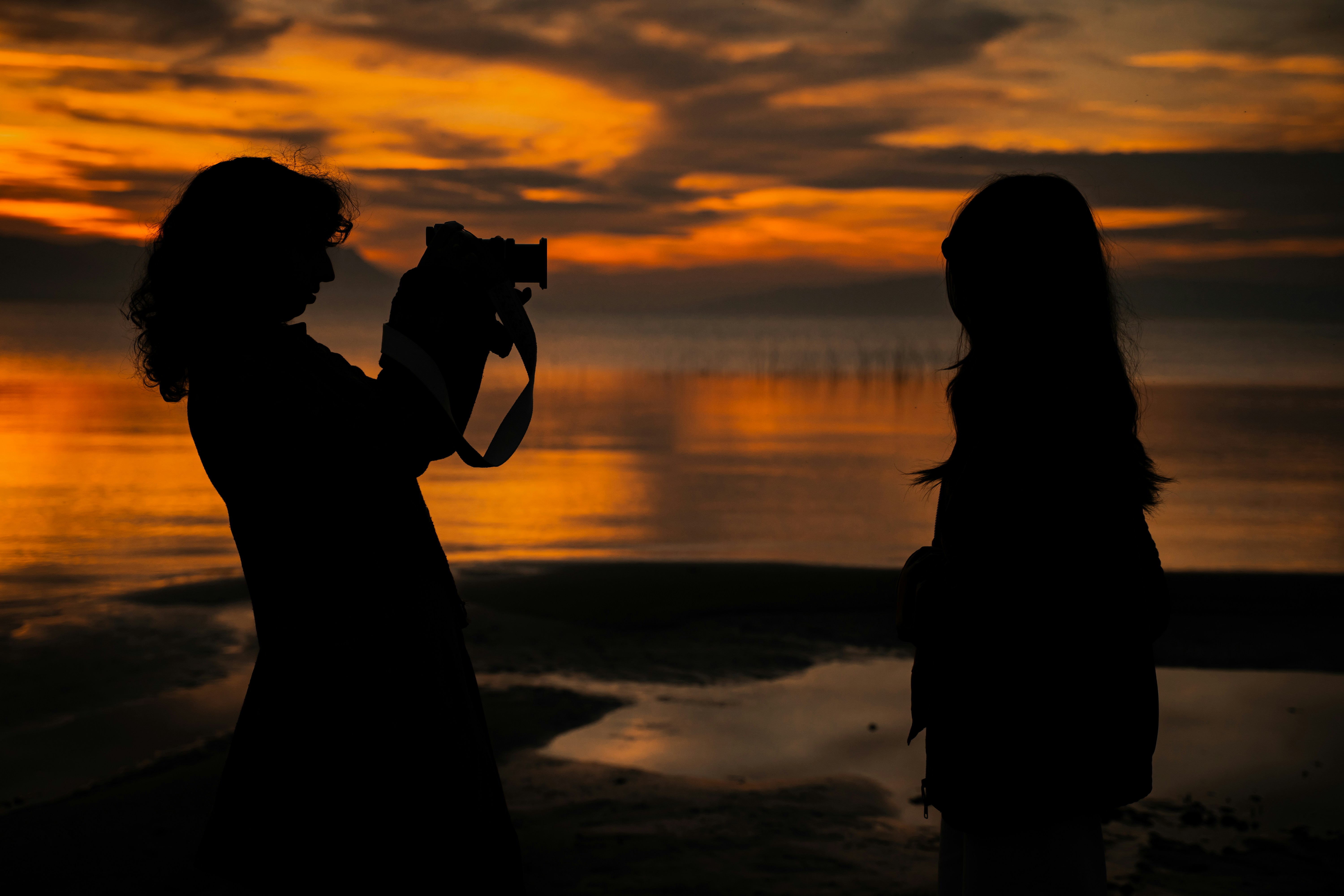Silhouetted Photographer and Subject at Sunset Beach