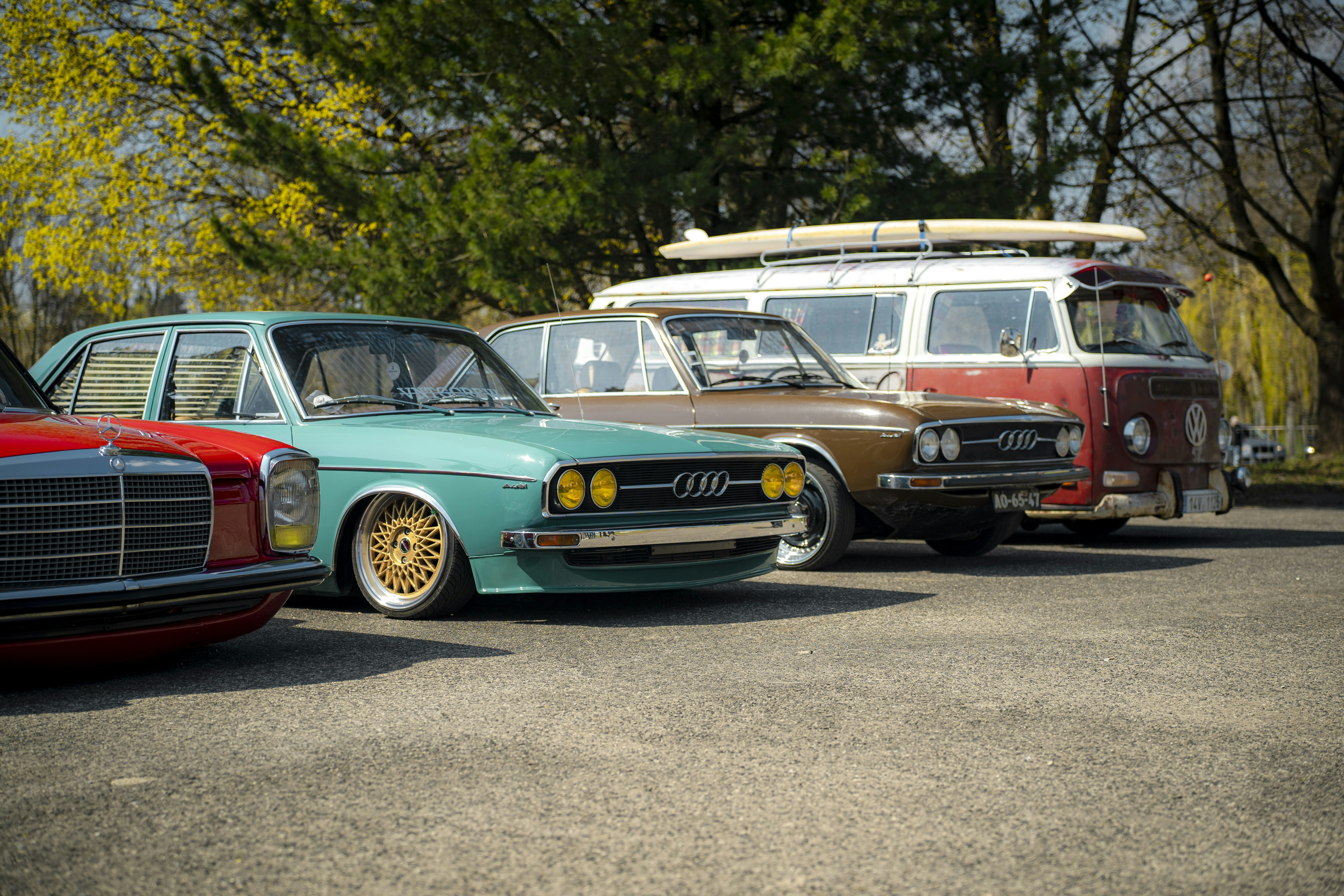 Line of Vintage Chrome: A Row of Classic Cars in a Sunlit Lot