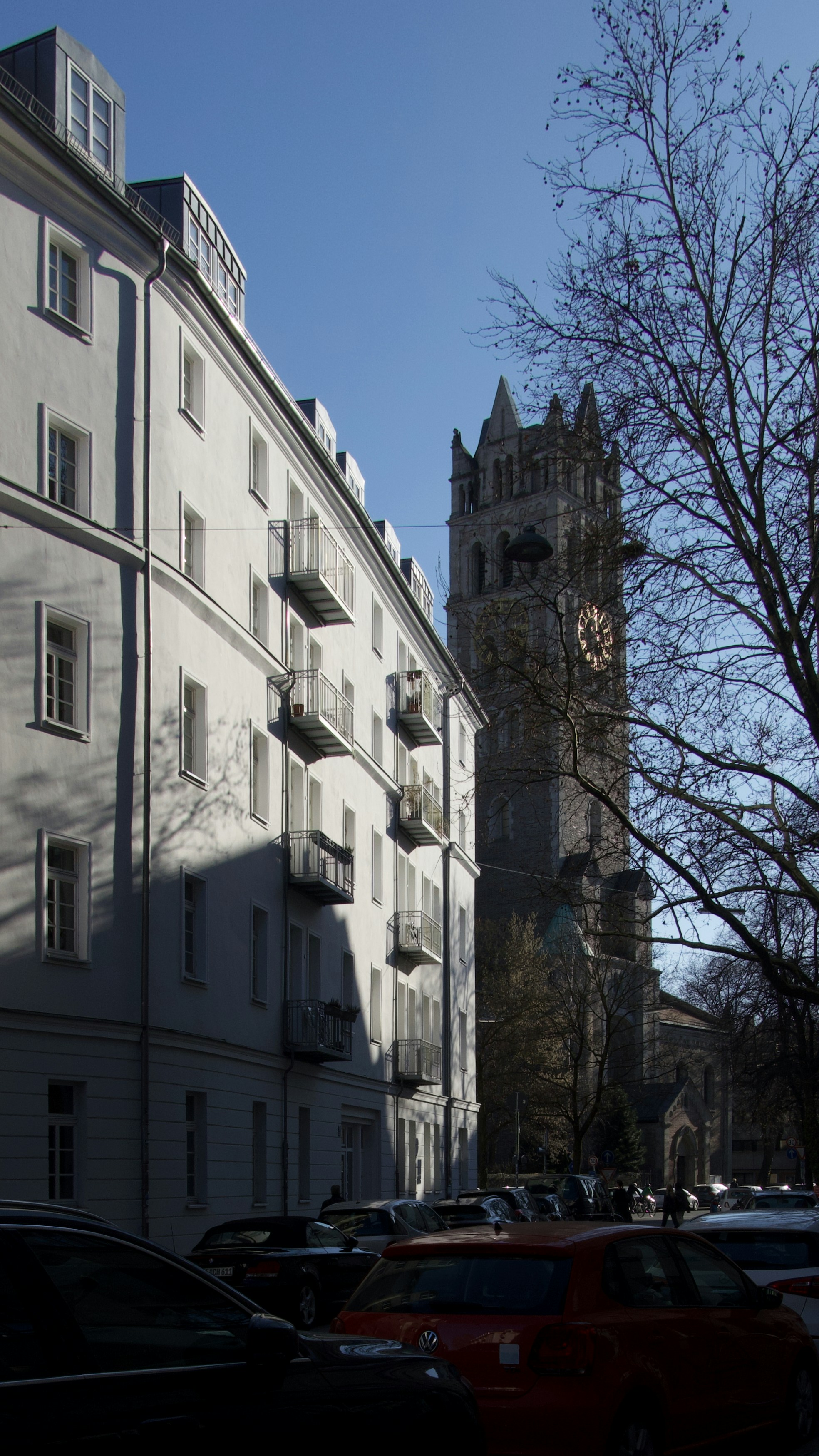 Towering Clock and Sunlit Apartment Facade