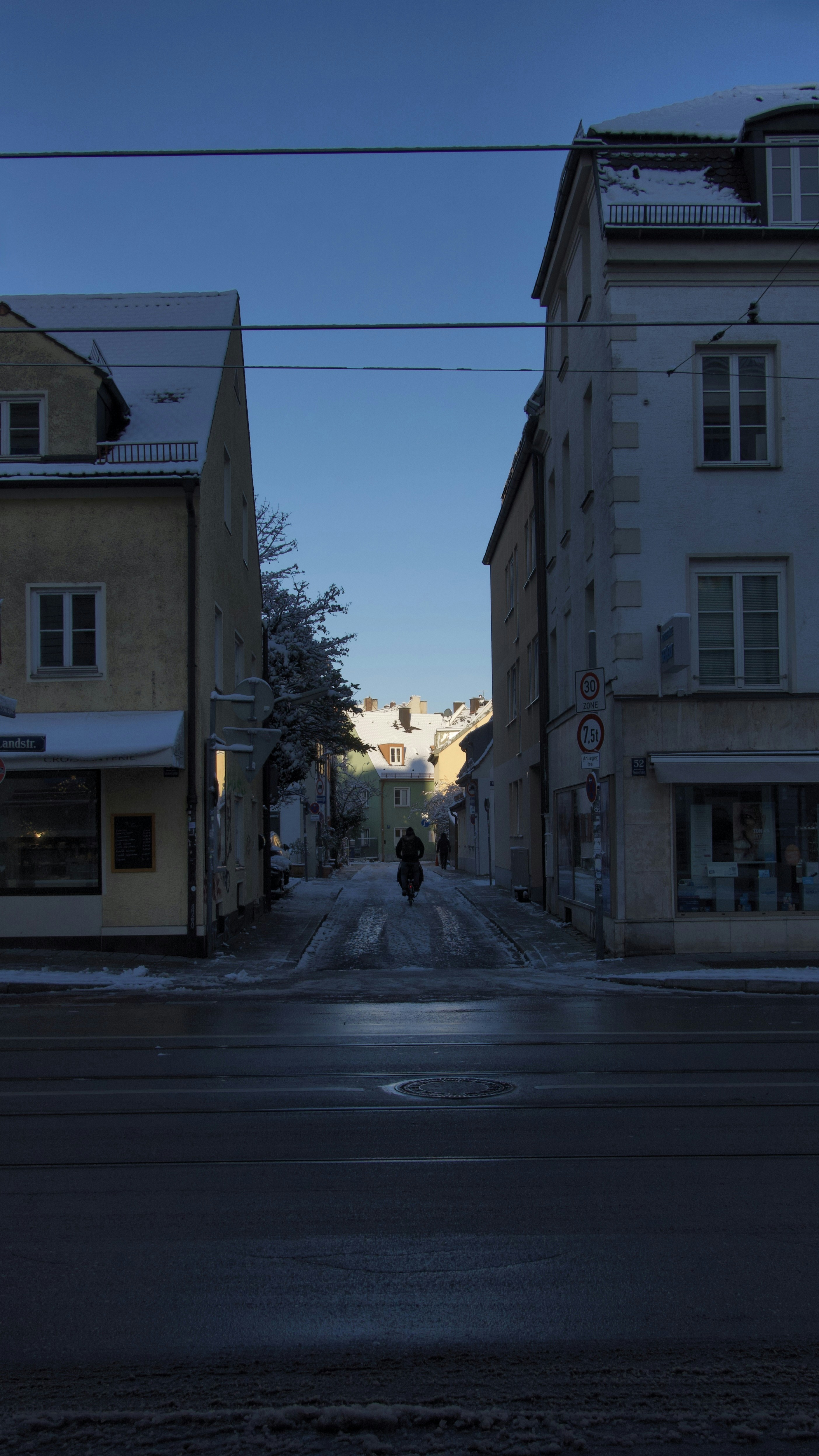 Sunlit alleyway framed by quiet city façades
