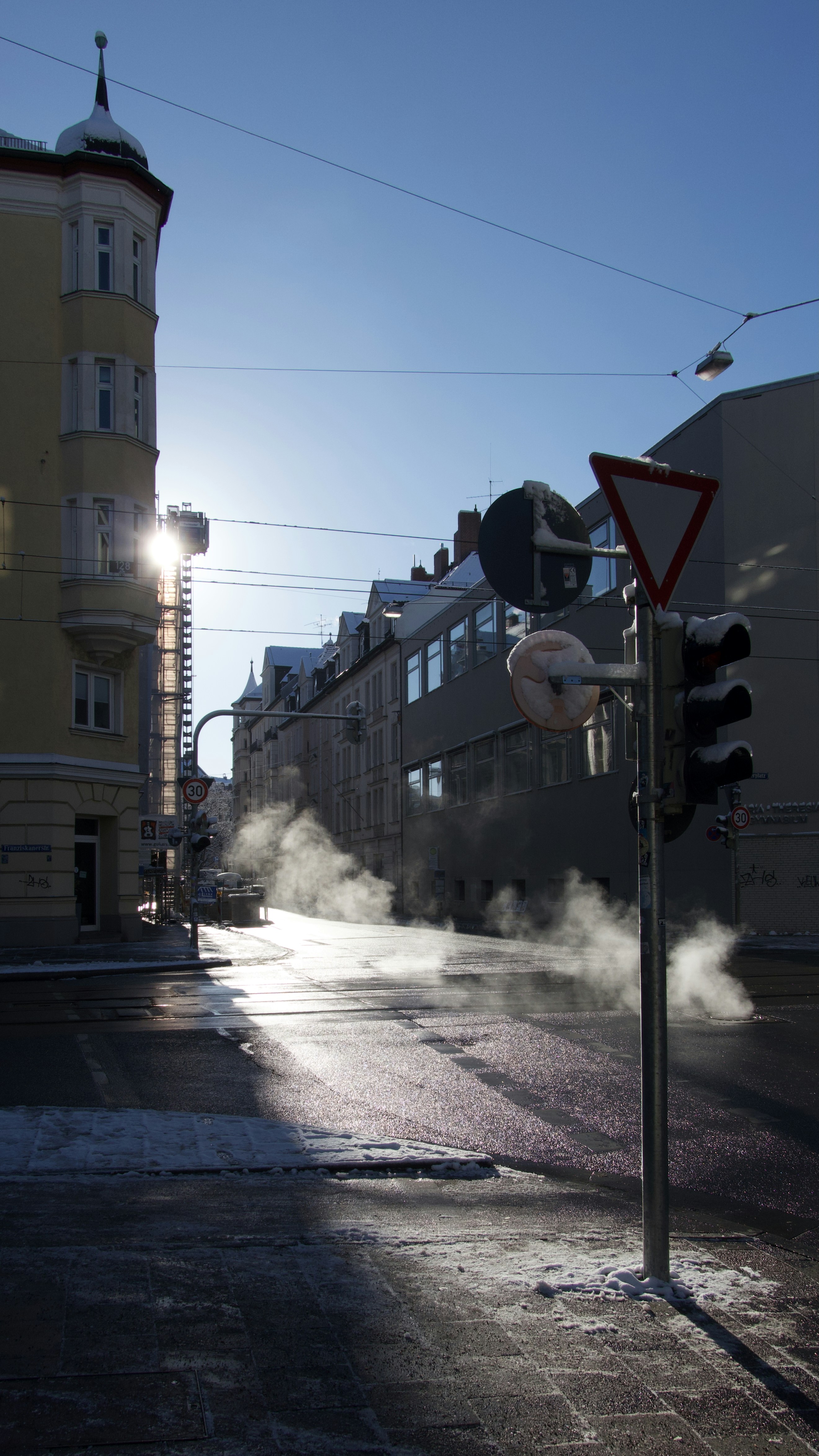 Steam Rising on a Sunlit City Crossing