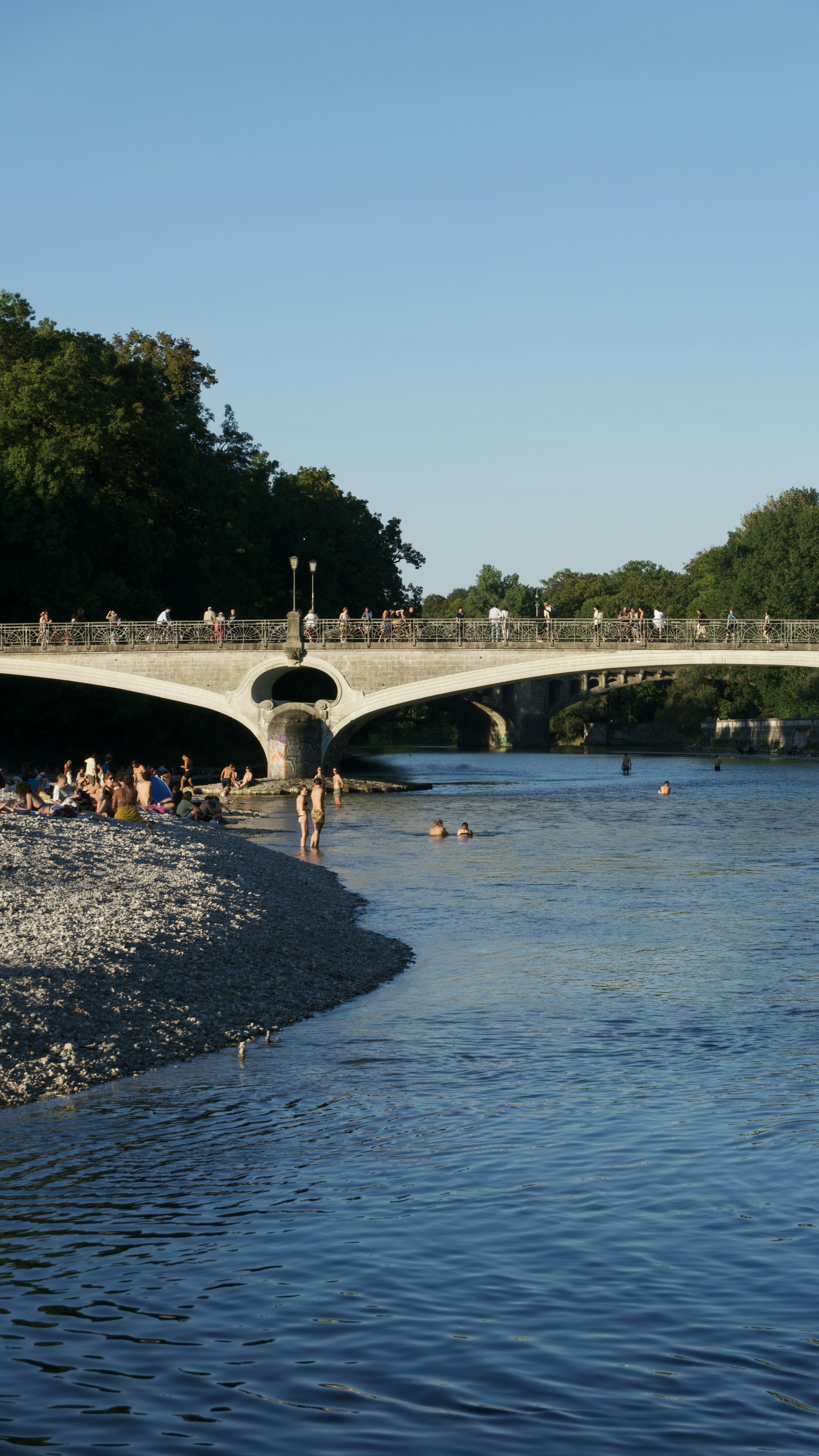 Bridge over Water: Sunlit Activity Beneath a Serene Sky