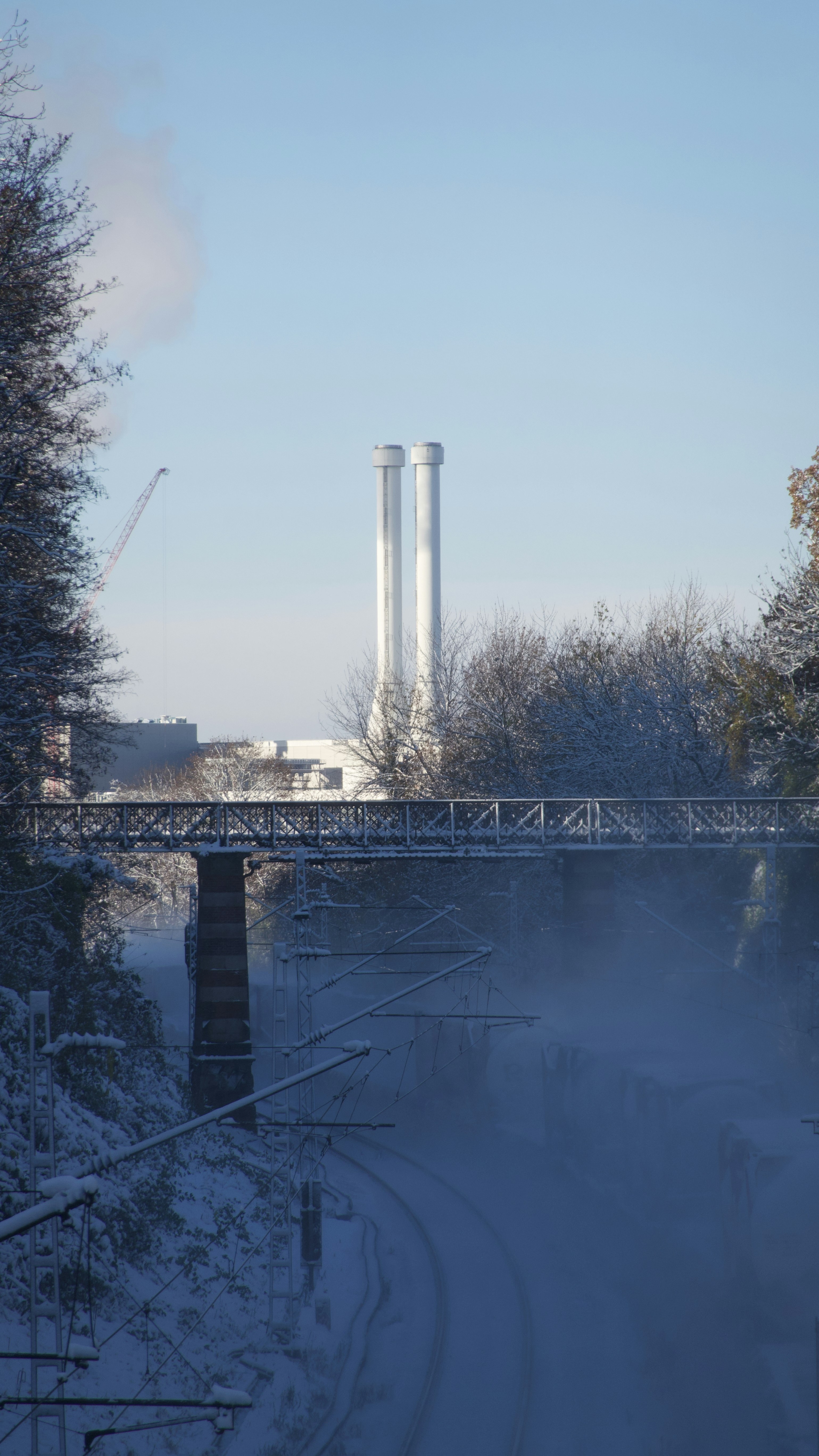 Twin chimneys against a winter skyline over railway tracks