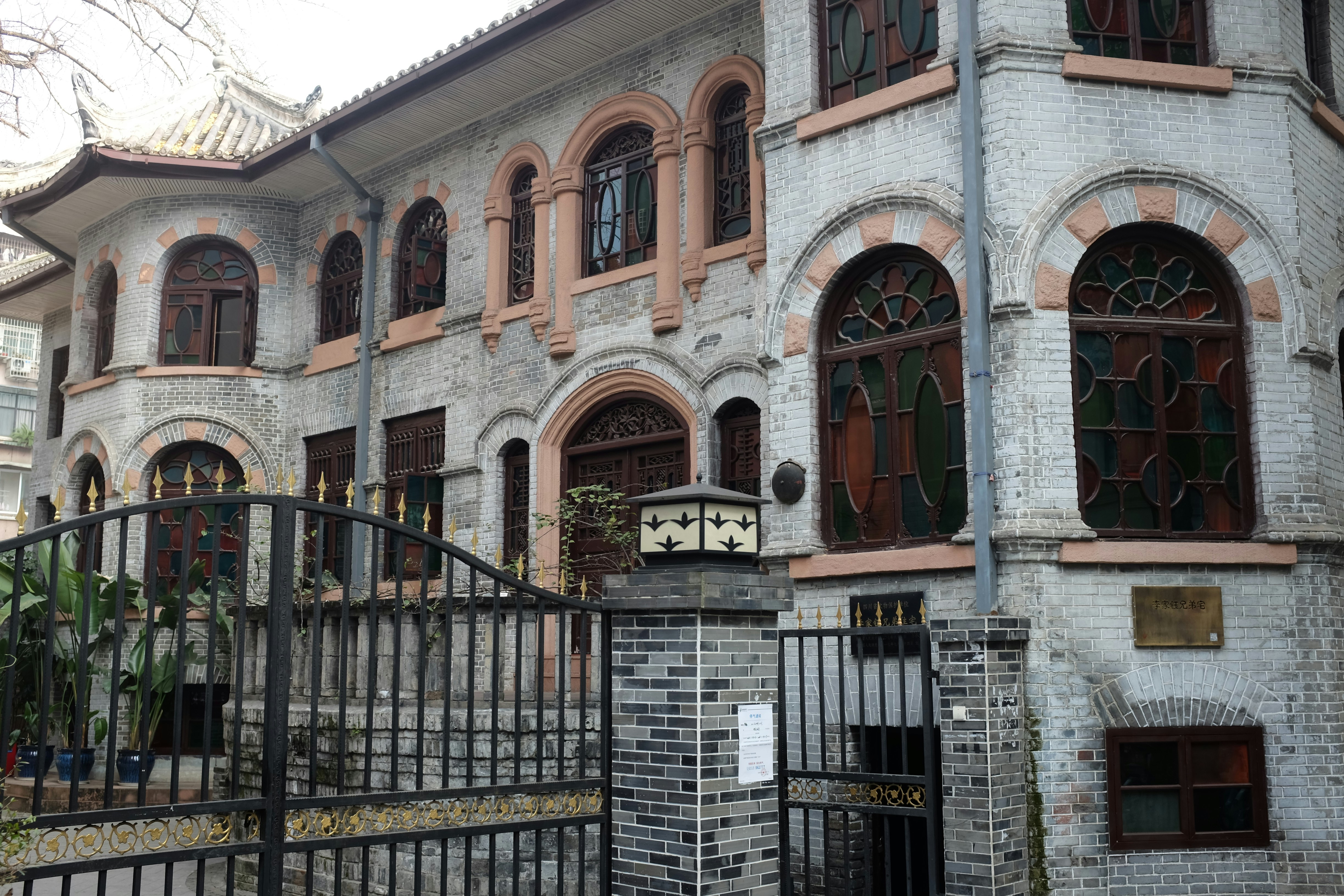 Arched Facade and Iron Gate of a Historic Brick Courtyard