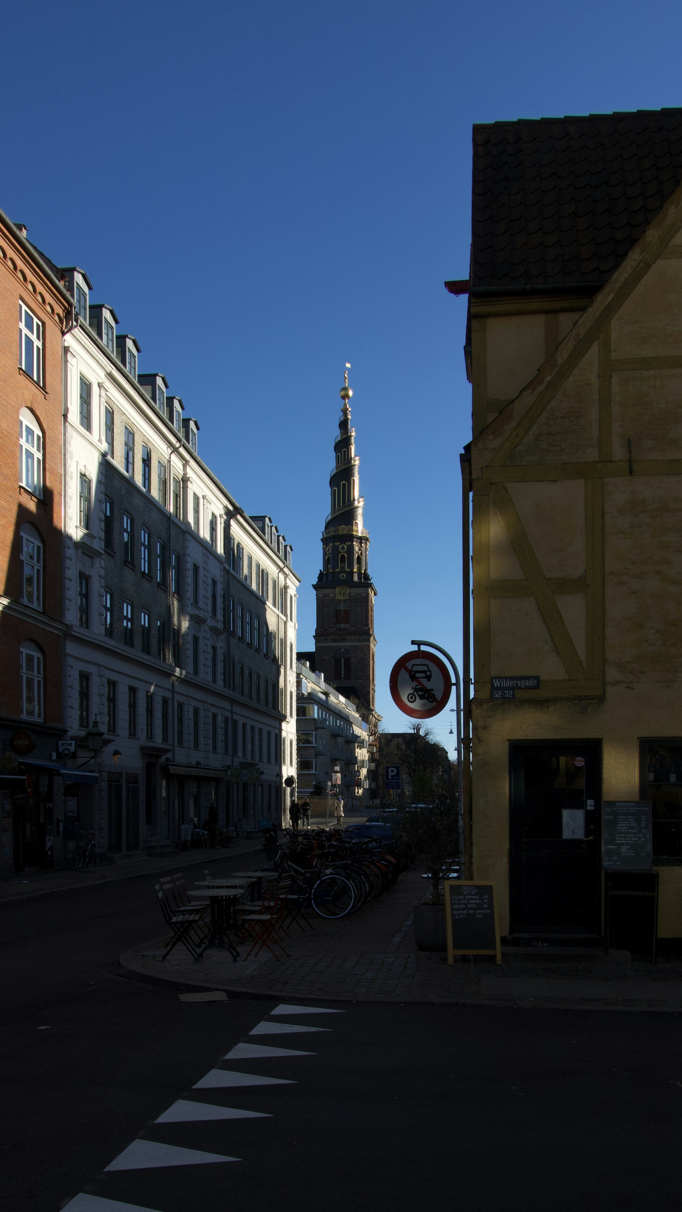 Spiral tower seen from a street with buildings.