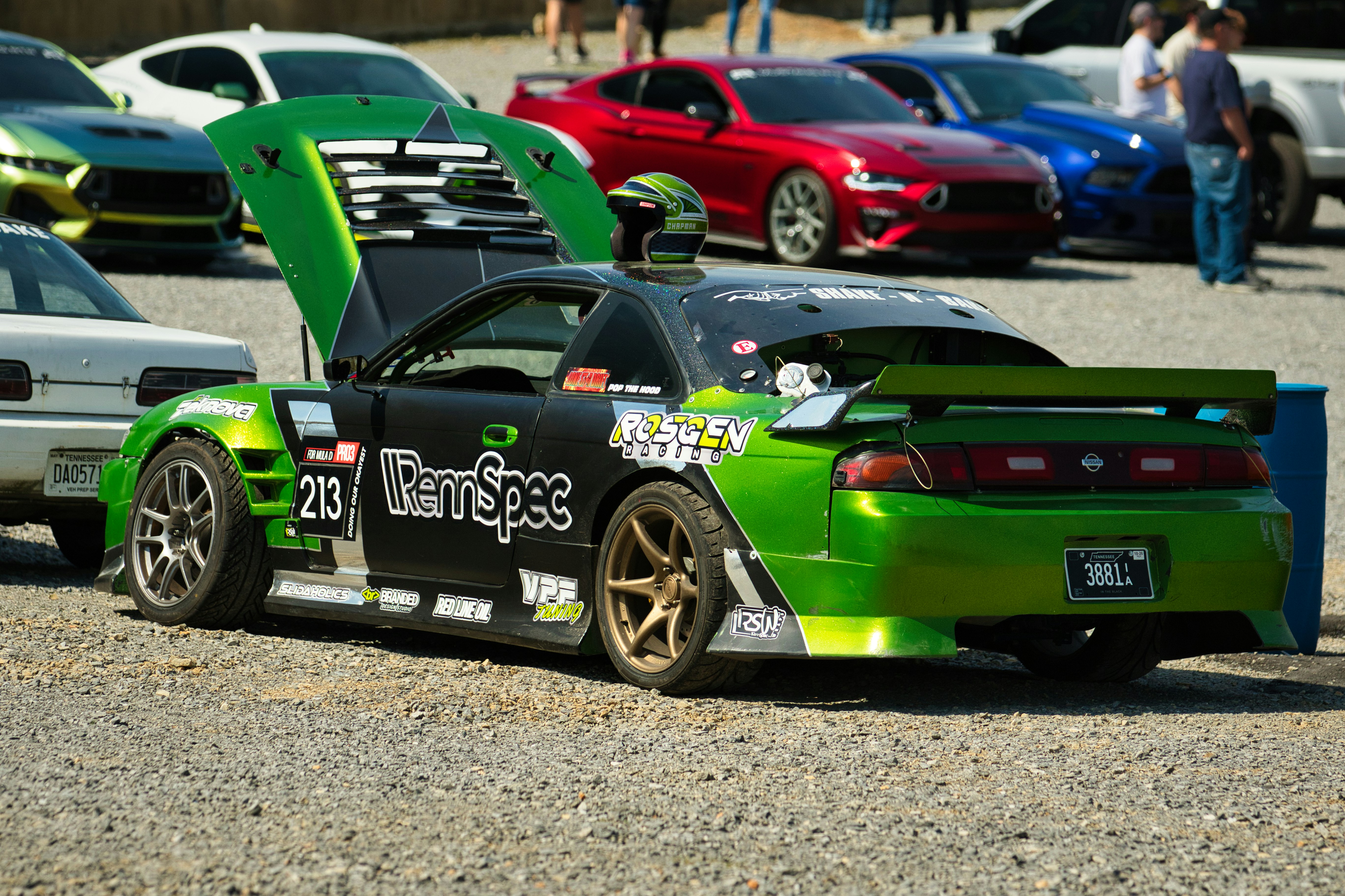 Green and Black Drift Car with Open Hood at a Car Show