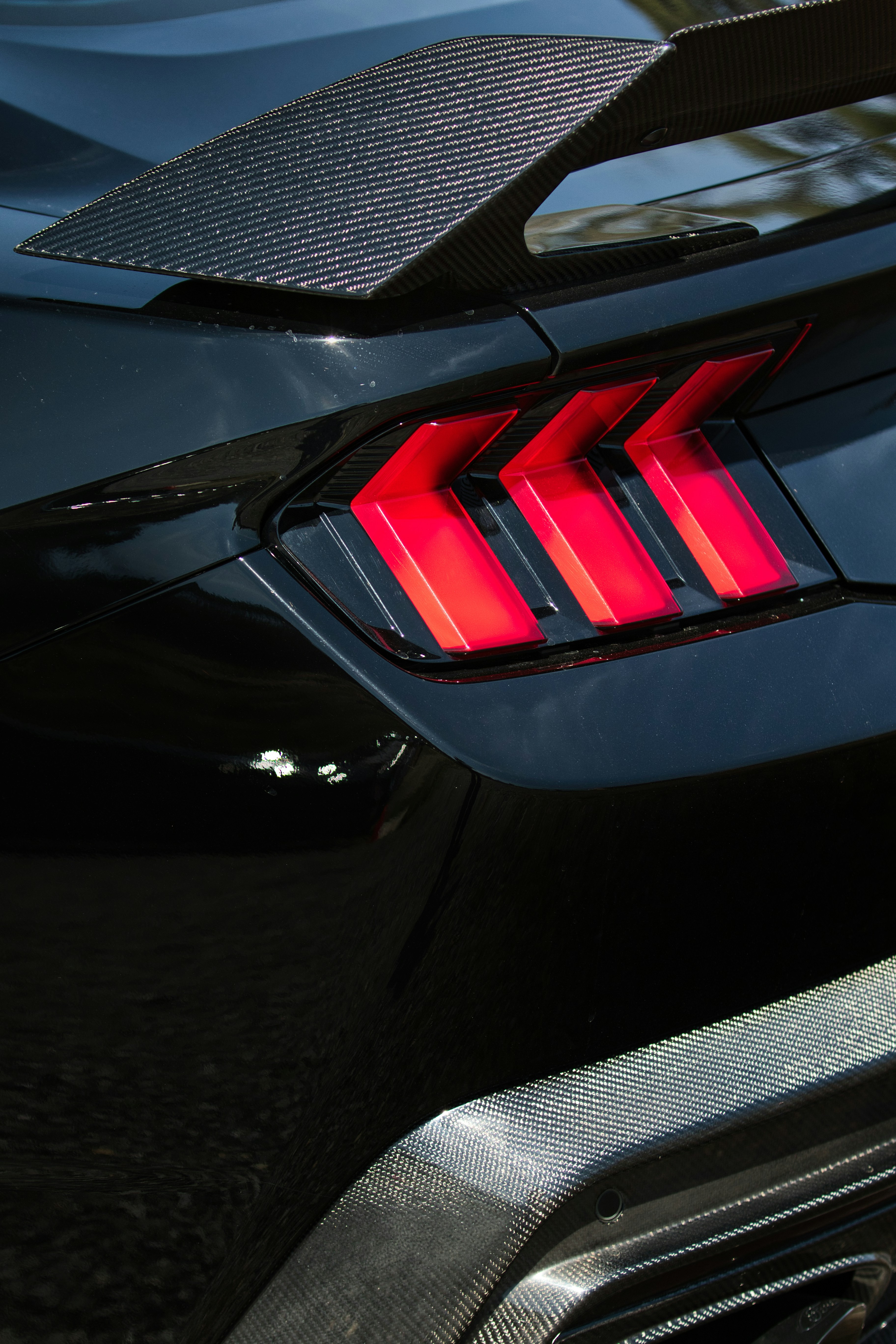 Redline Reflections: A Carbon-Texture Taillight Snapshot