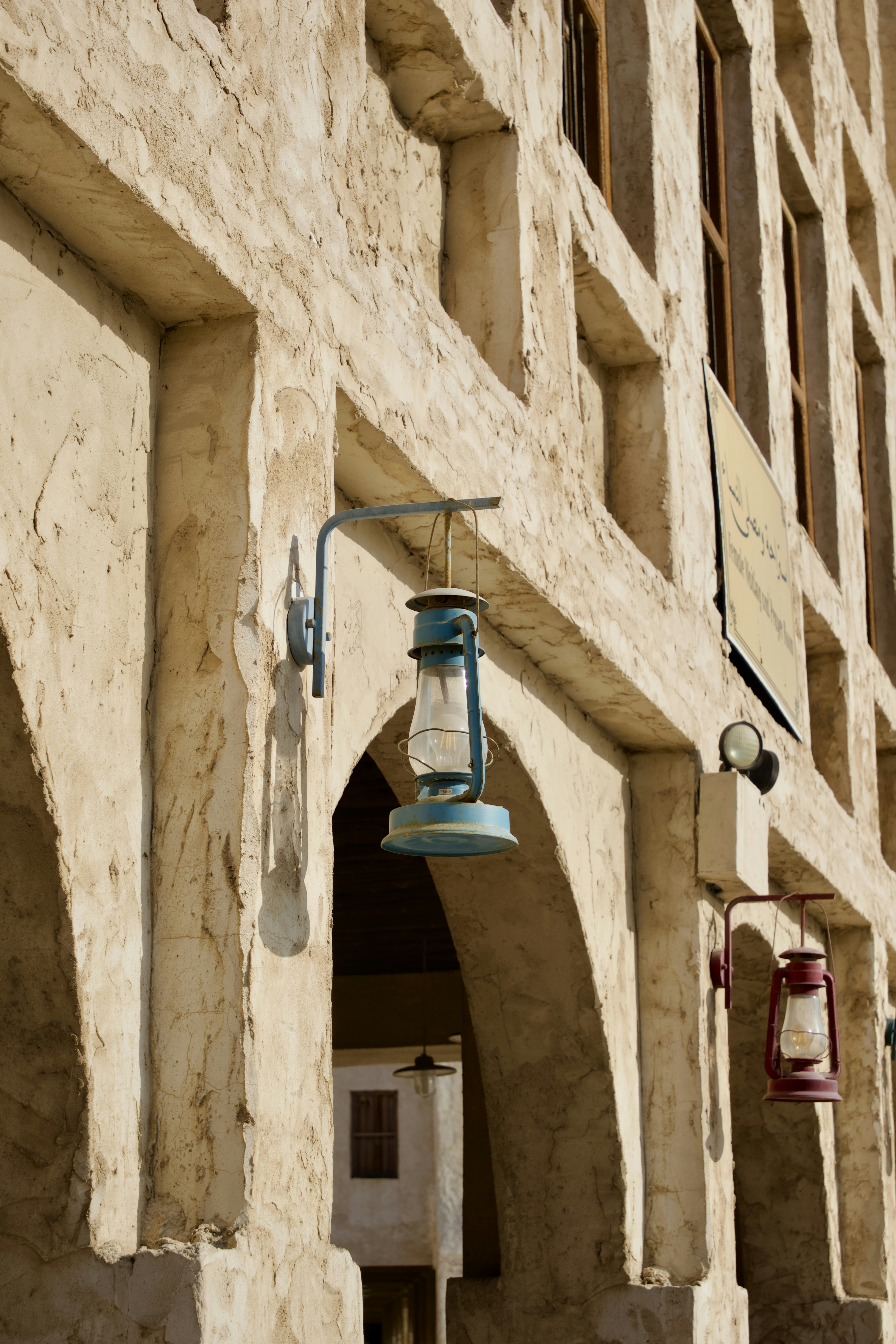 Blue Lanterns on a Sunlit Arcade