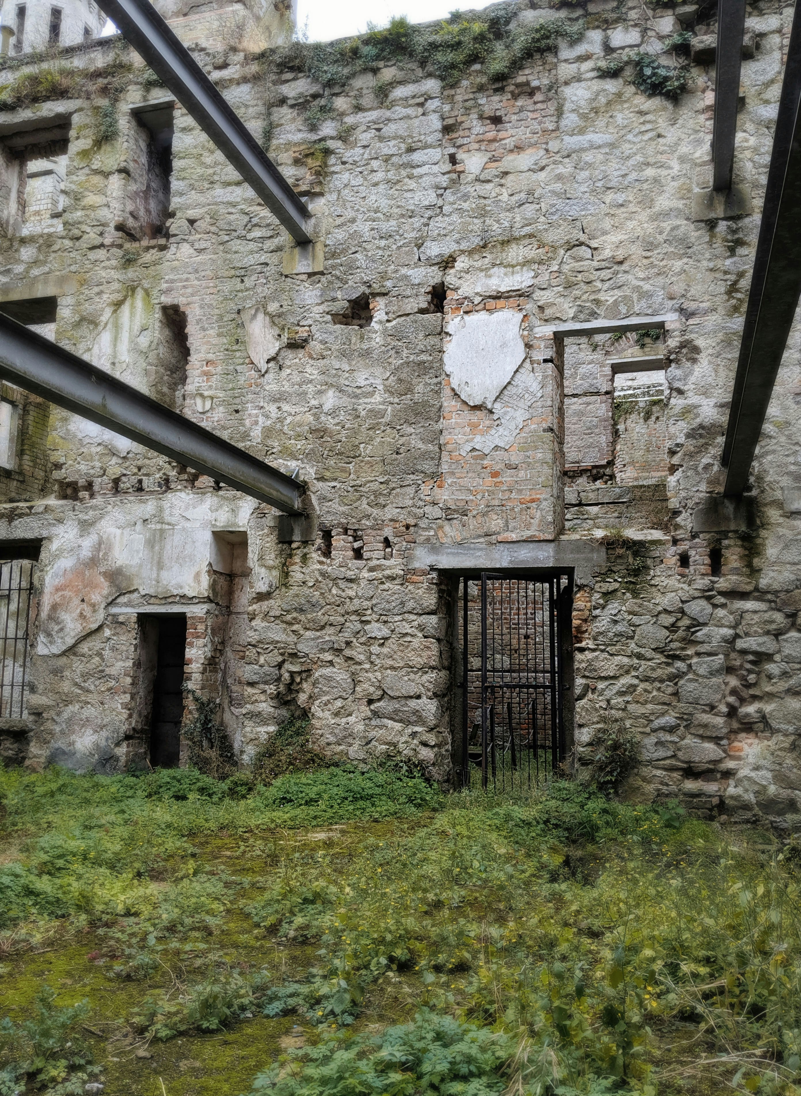 Ruined Stone Wall with Iron Beams and Overgrown Foreground