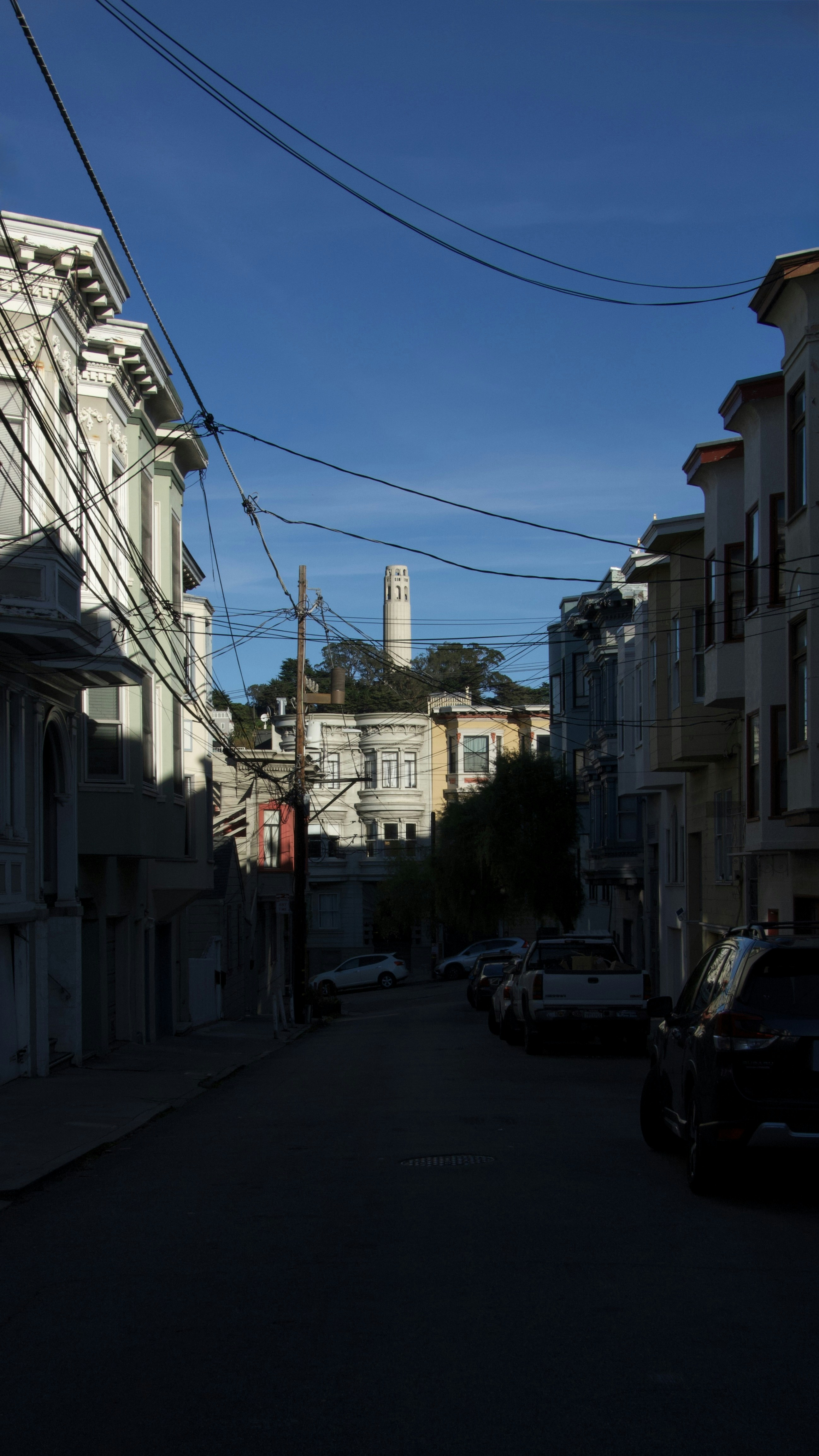 Tower of Blue Sky: An Urban Canyon Framed by Wires and Facades