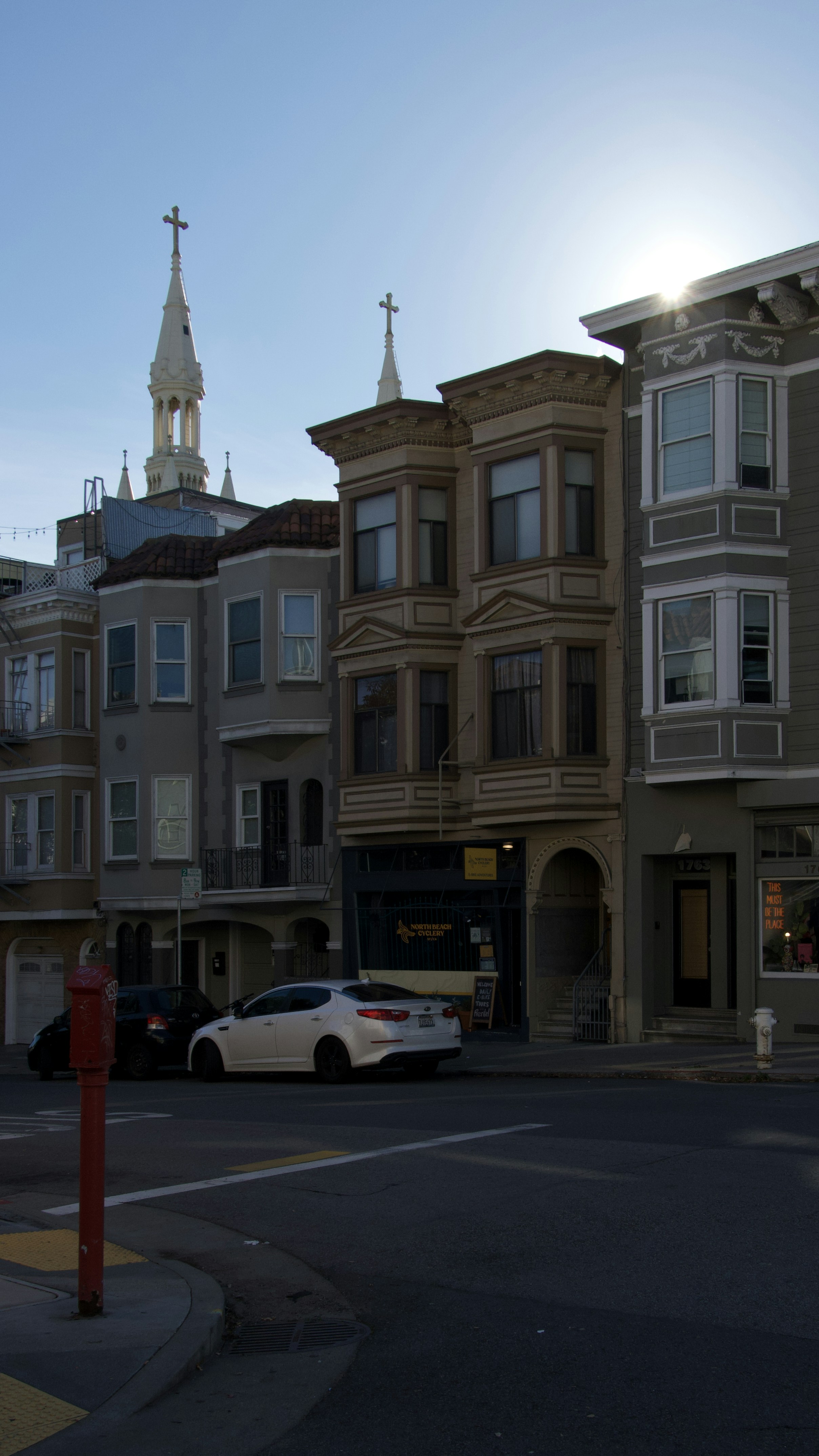 Sunlit Upper East Facade: San Francisco-Style Row with Church Spire