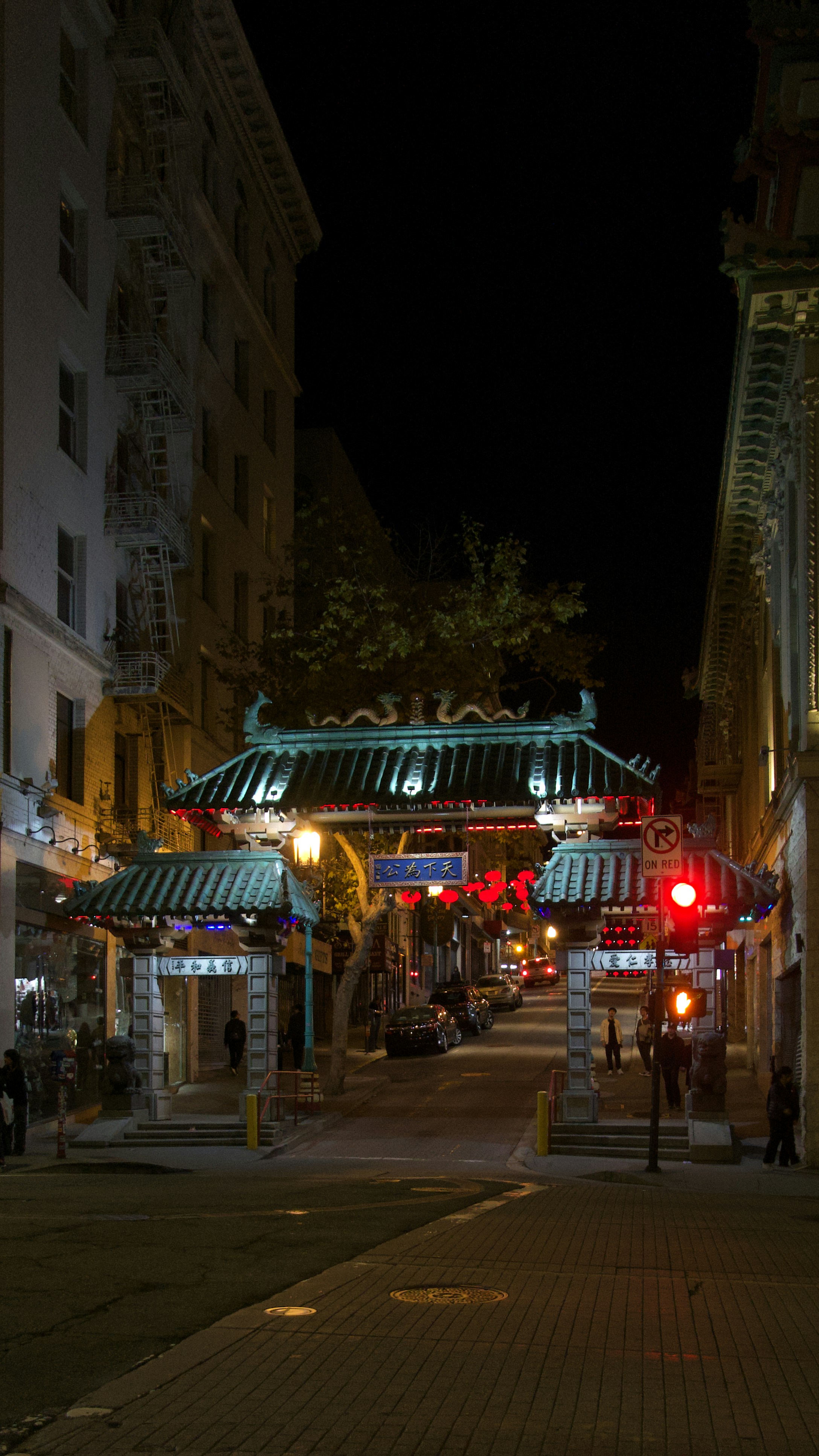 Chinese gate at night with red lanterns and traffic lights