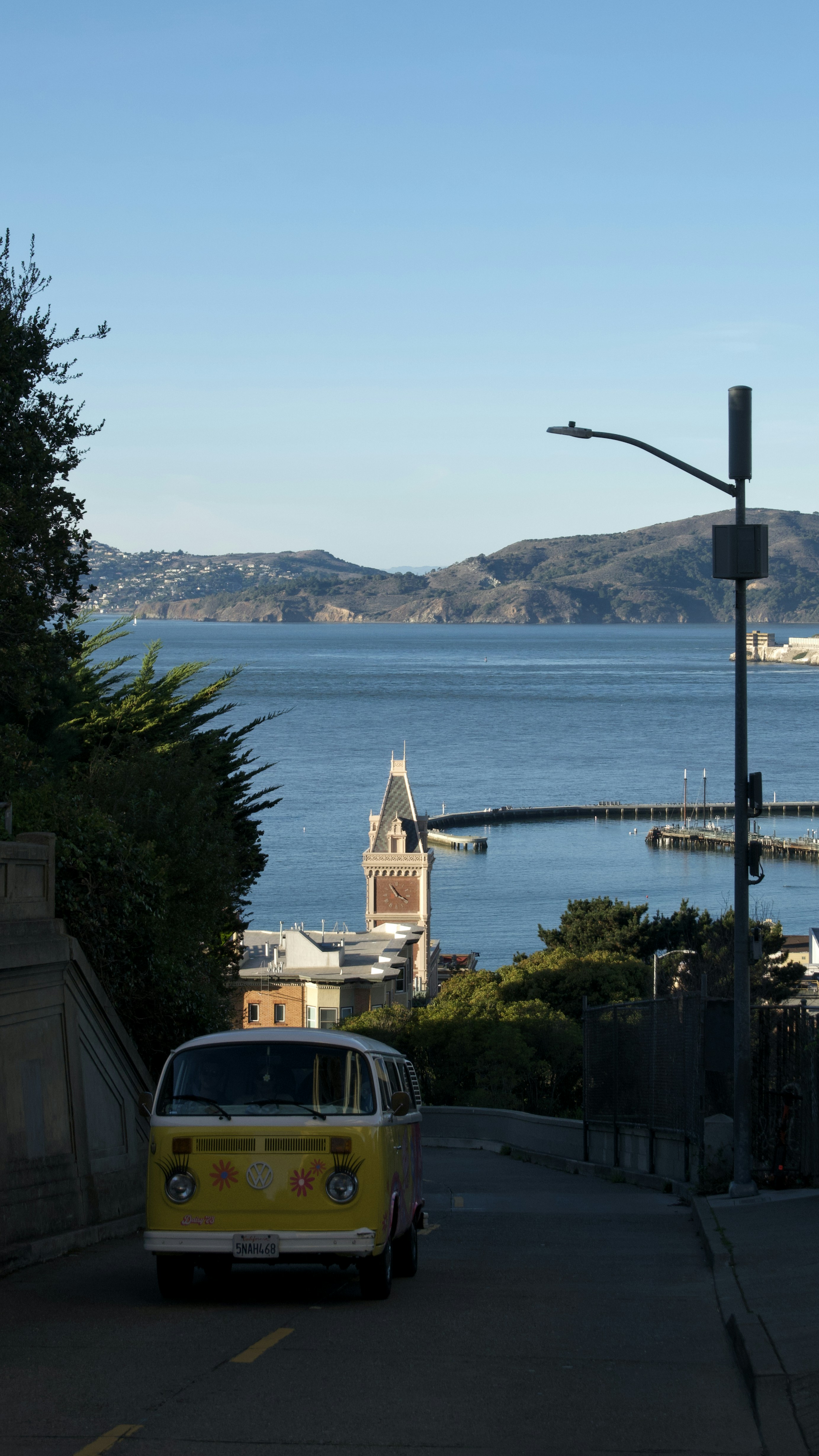 Sunlit Coastal Climb: A Yellow VW Flags the Path to the Bay