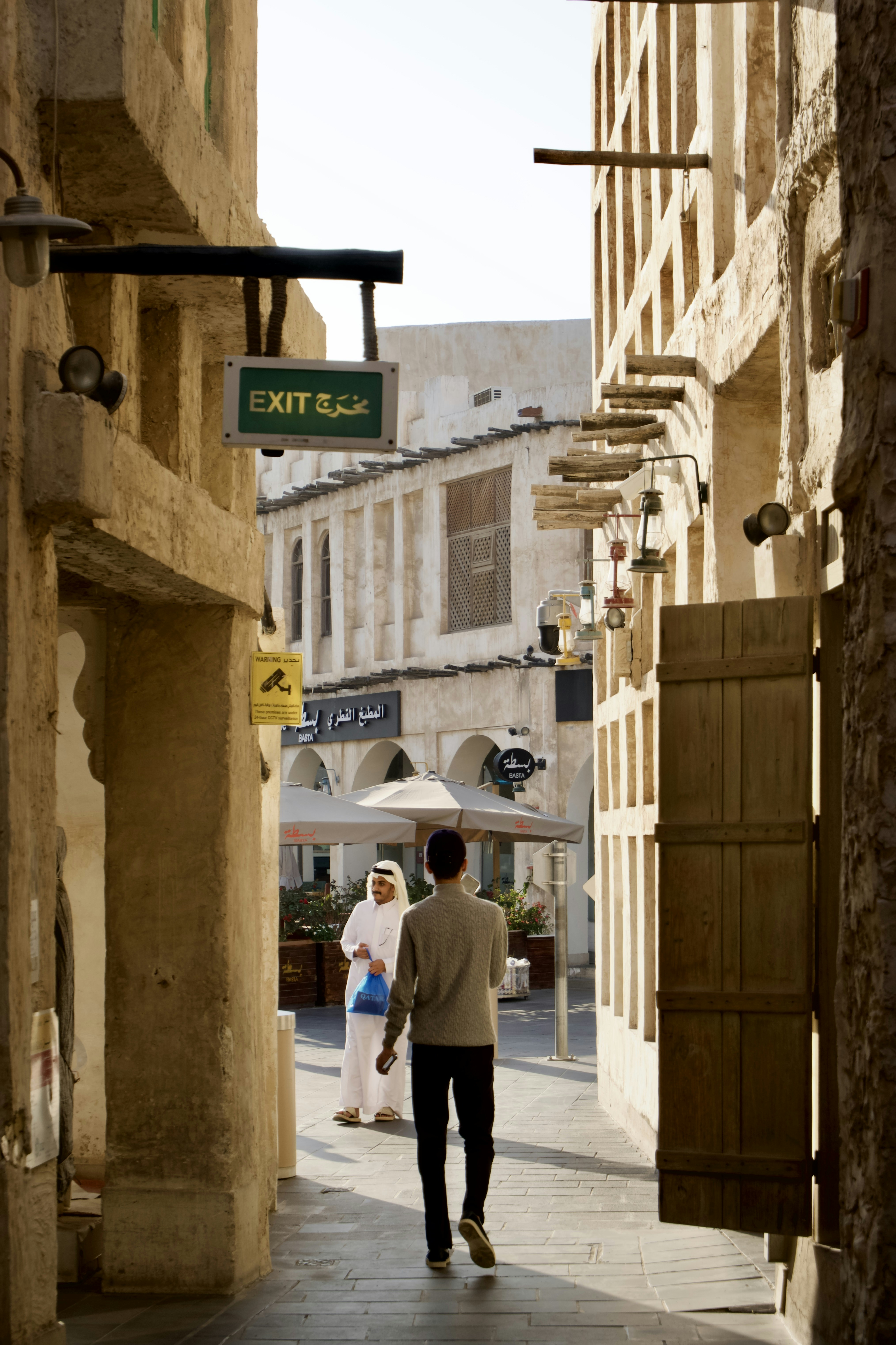 Quiet Alleyway Escape: A Man Walks Toward Light Beyond the Arch