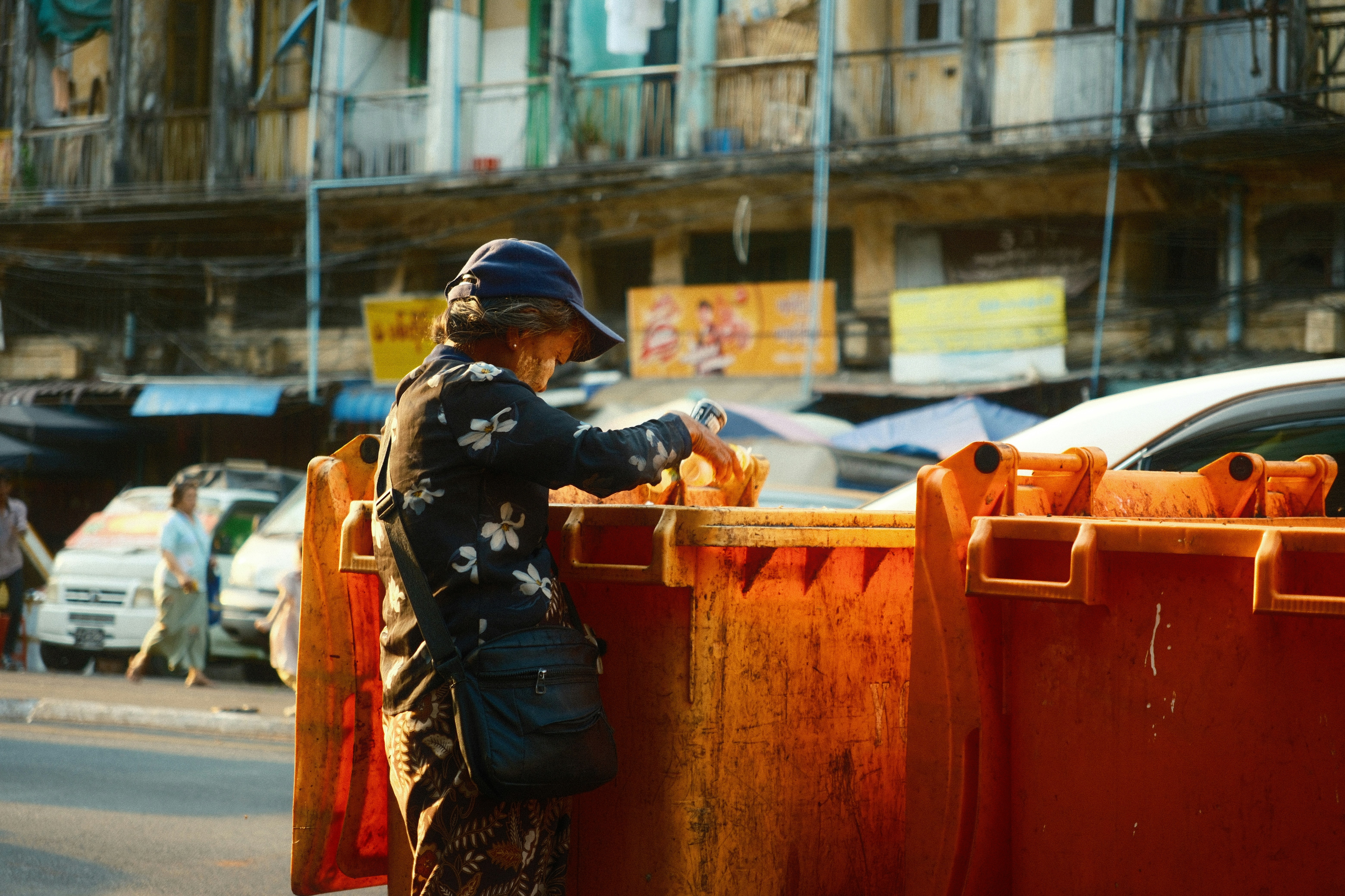 Morning Market Stopover: A Woman at the Orange Dumpster